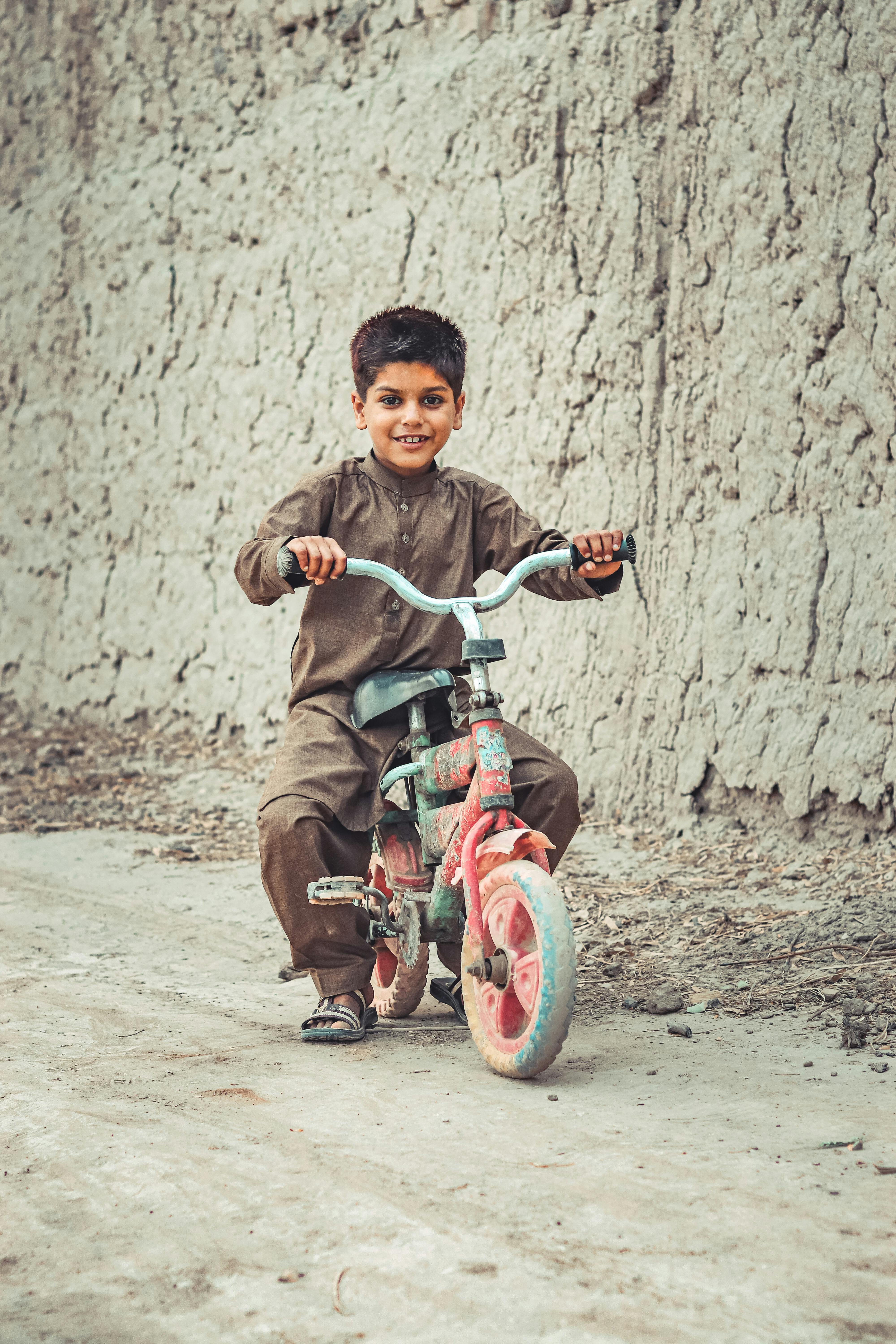 Boy in Brown Kurta Set Riding on Bicycle · Free Stock Photo