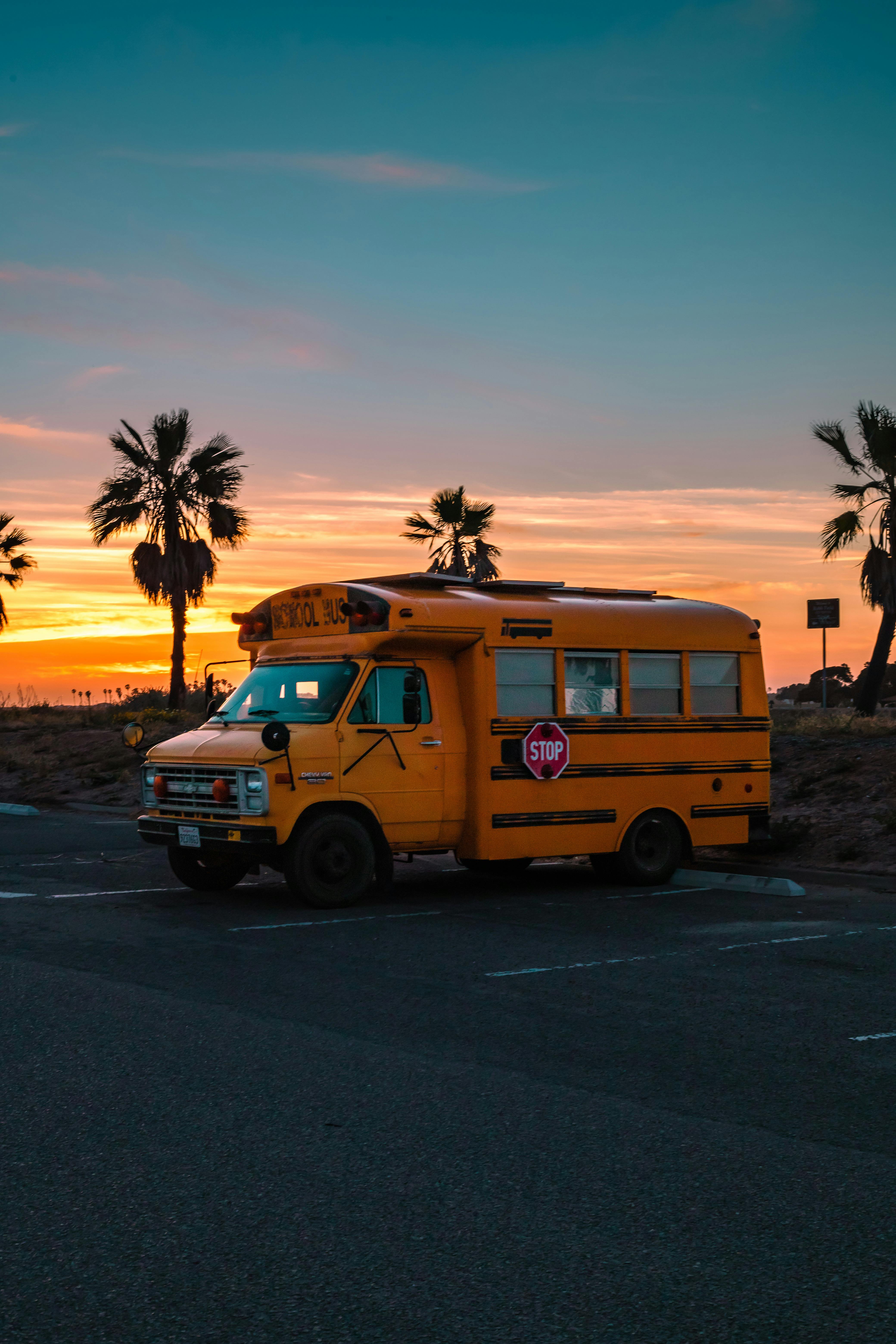 Yellow School Bus Parked Between Tall Buildings · Free Stock Photo