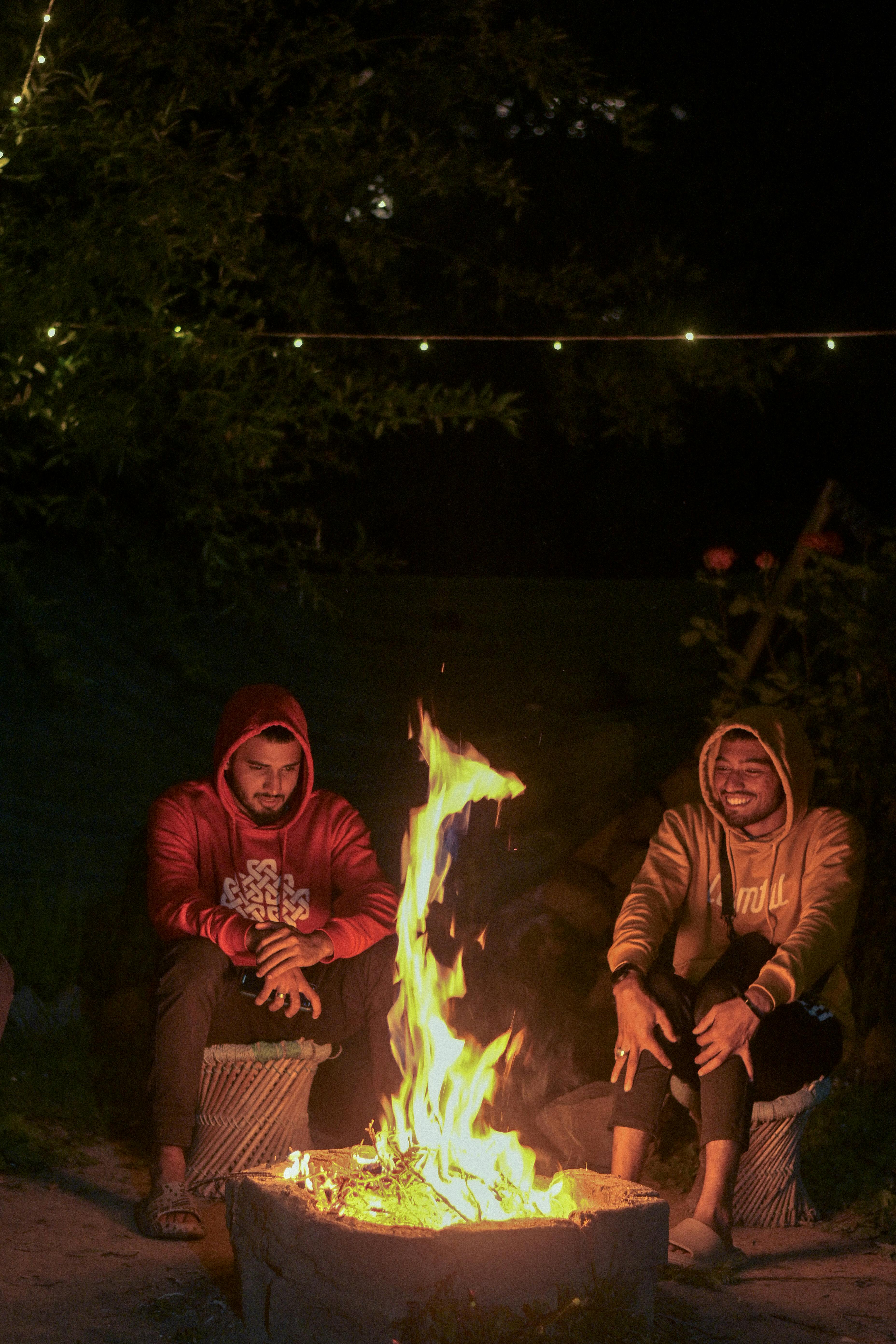 Men in Hoodie Sweaters Sitting Beside a Bonfire · Free Stock Photo