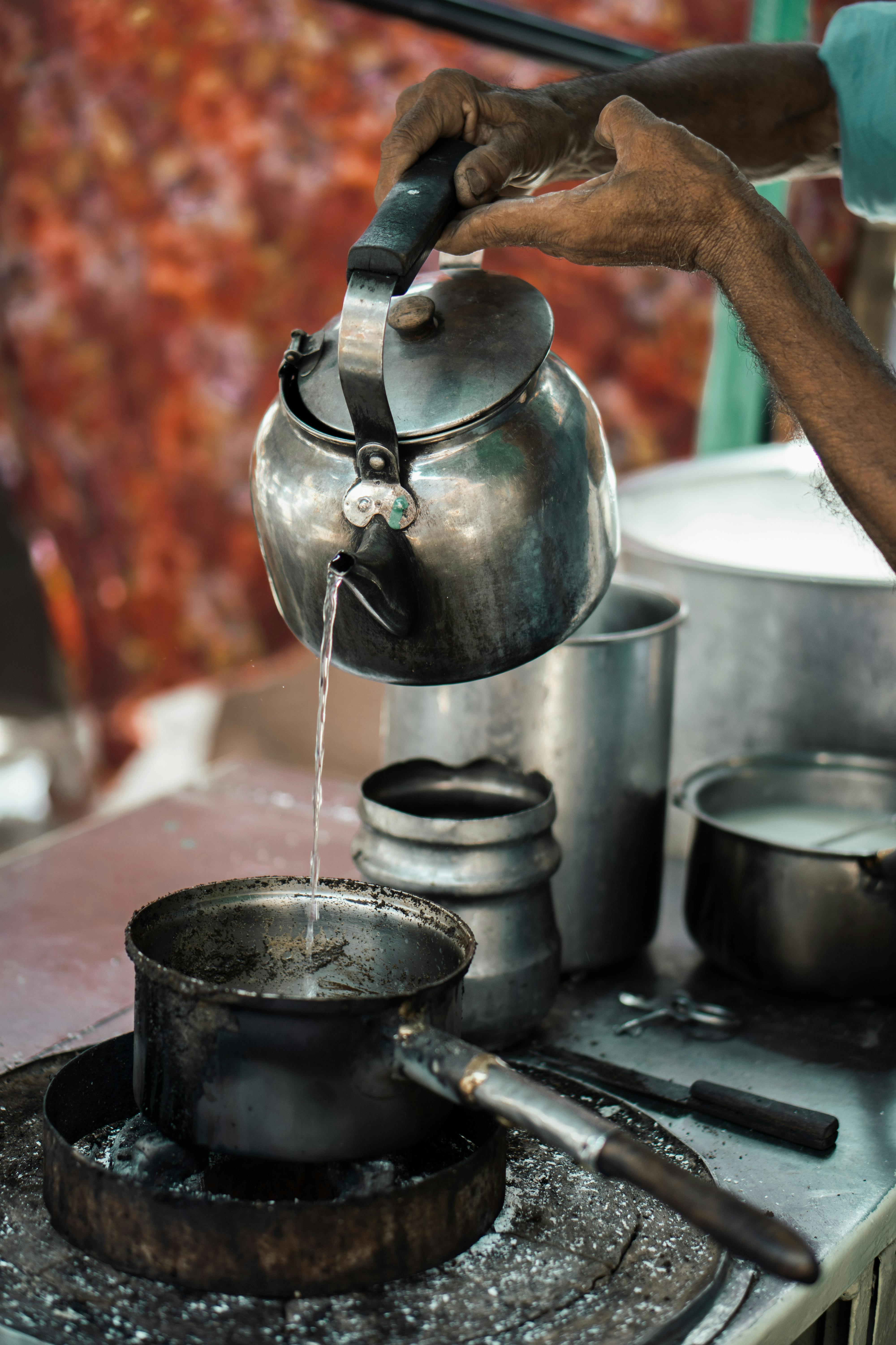Person Holding Red Pot Filled with Water · Free Stock Photo