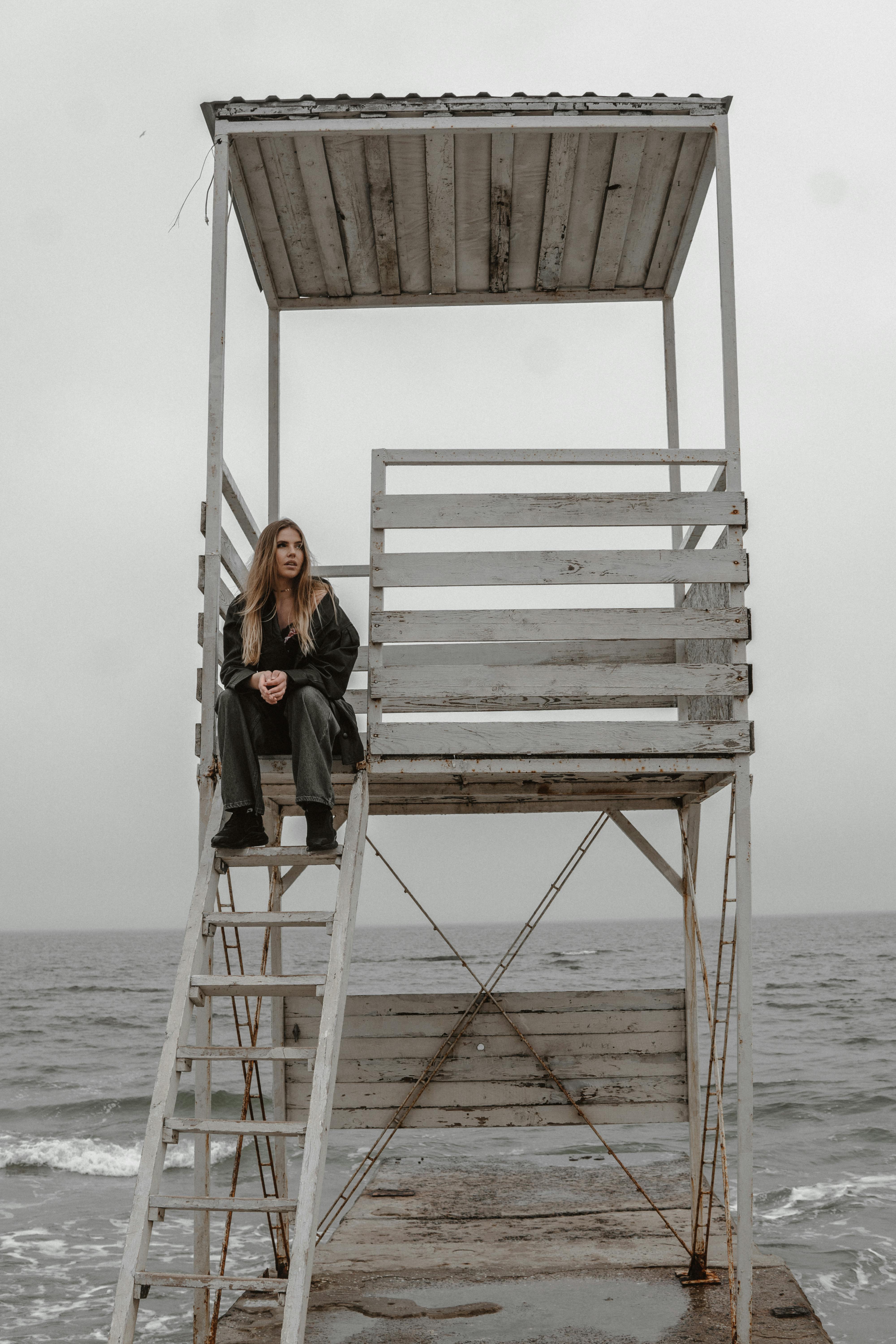 Woman Sitting on Lifeguard Tower on Beach · Free Stock Photo