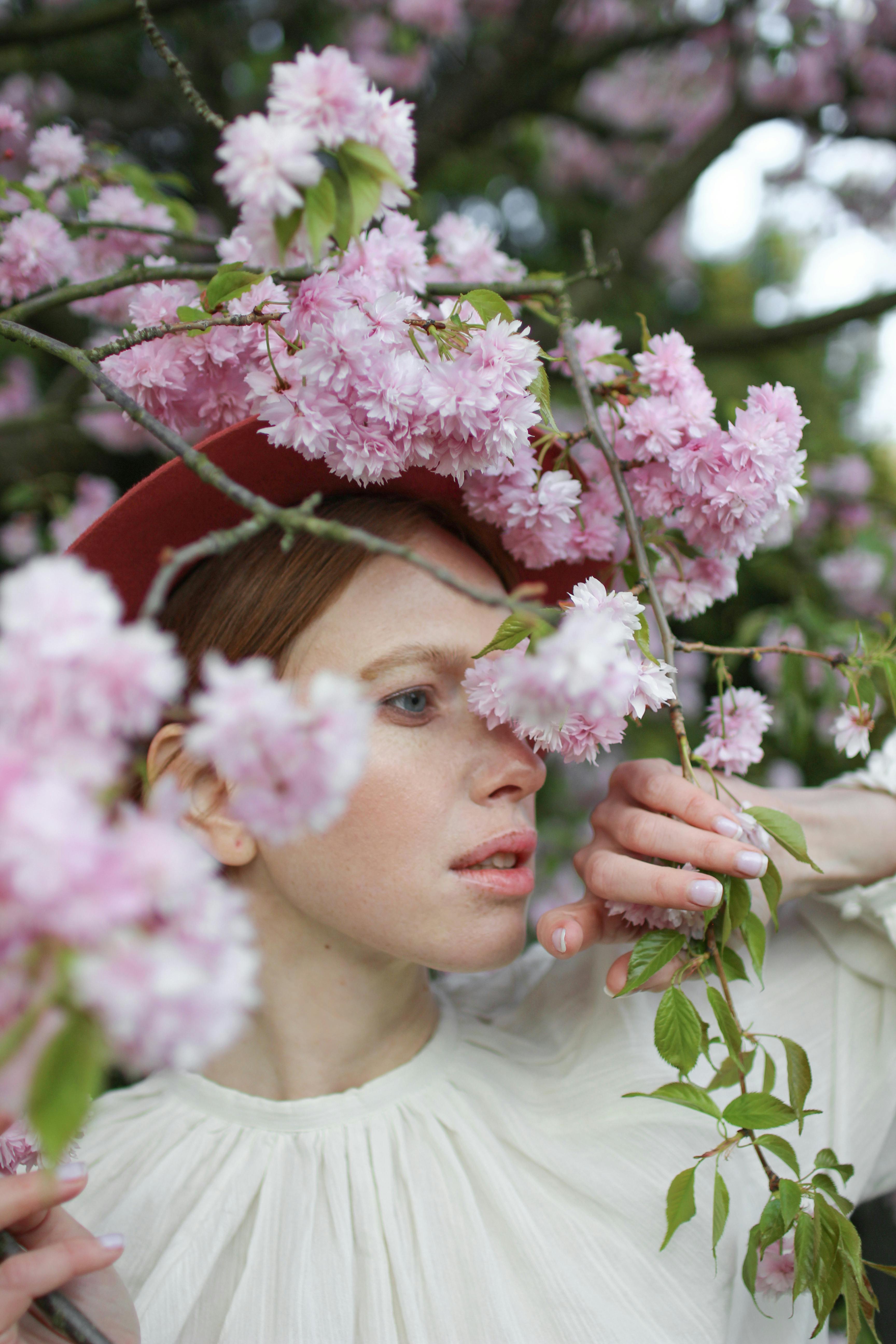 Woman Squatting Beside Purple Flowers · Free Stock Photo