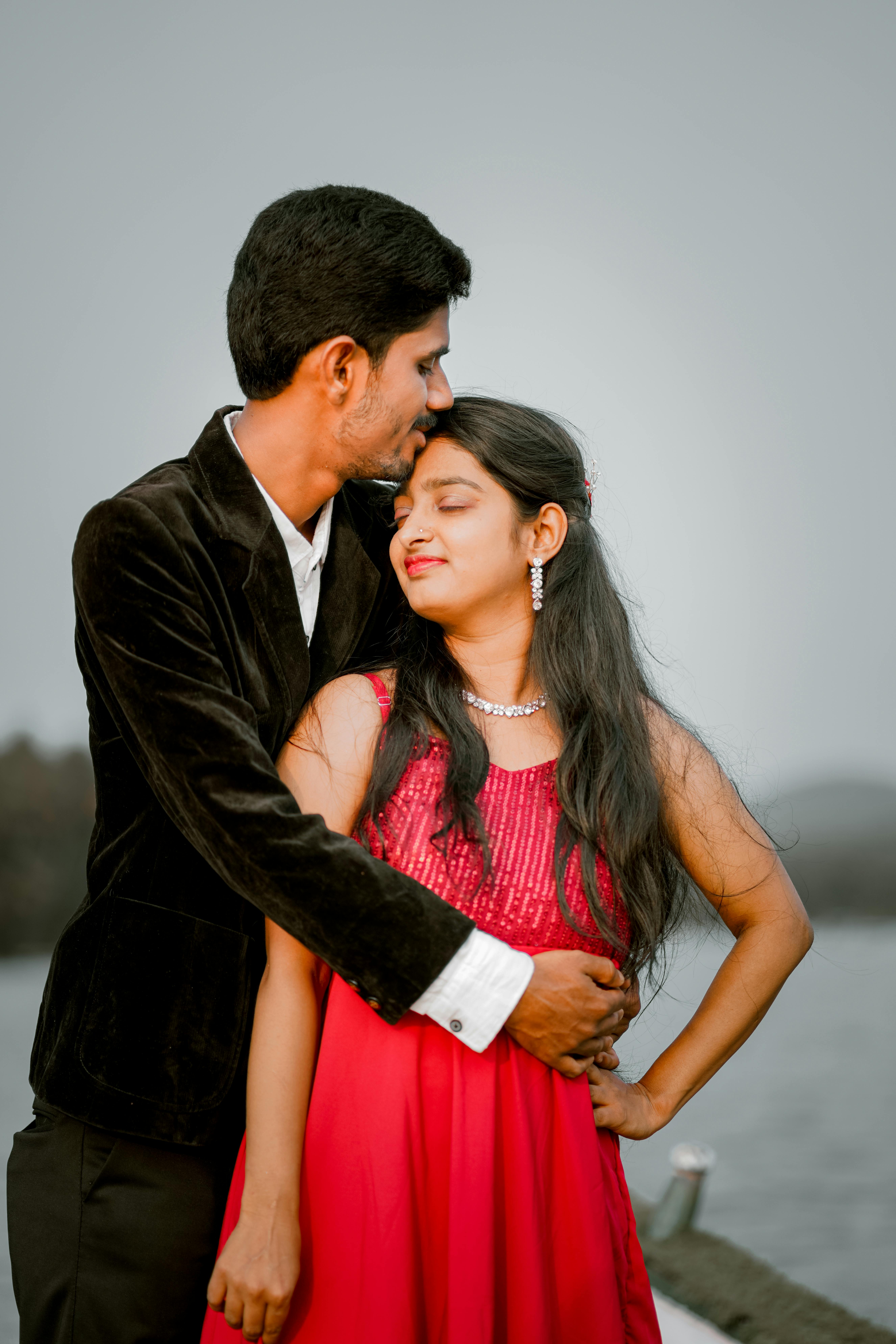 Man in Black Suit Kissing Woman in Red Dress · Free Stock Photo