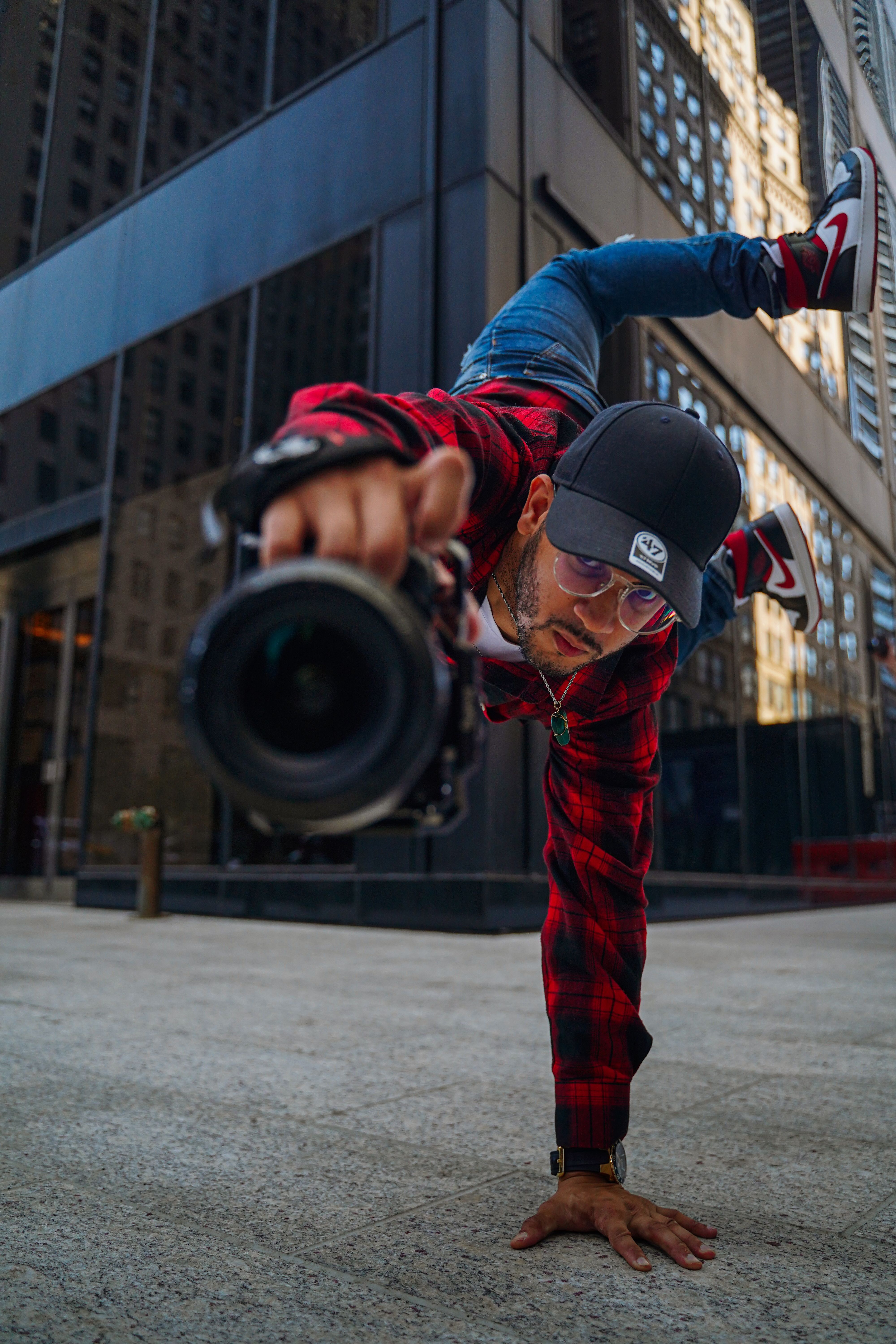 Man Standing on One Hand and Holding a Camera · Free Stock Photo