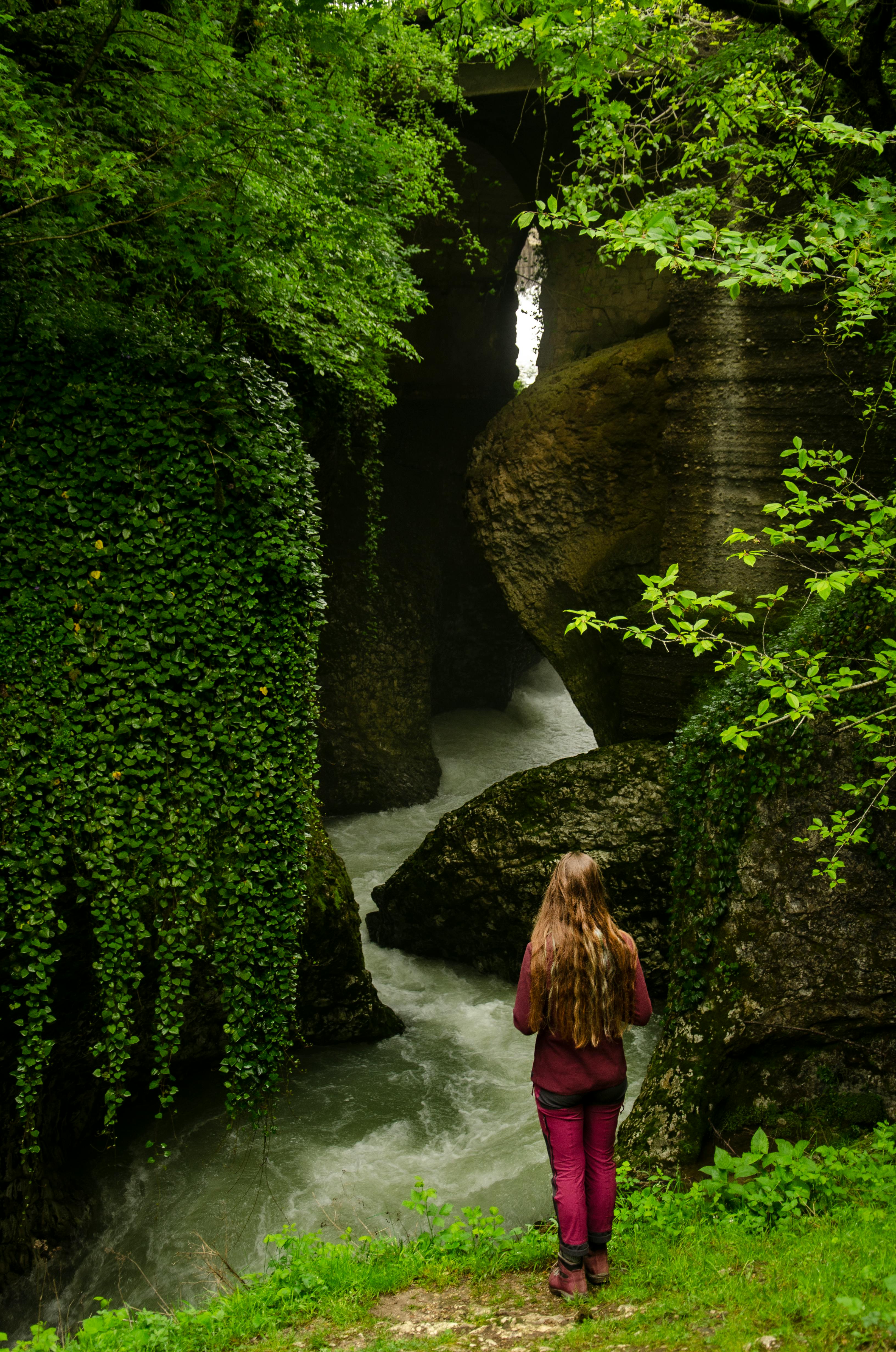 A Woman Wearing a Hard Hat Standing under Rock Formations · Free Stock ...