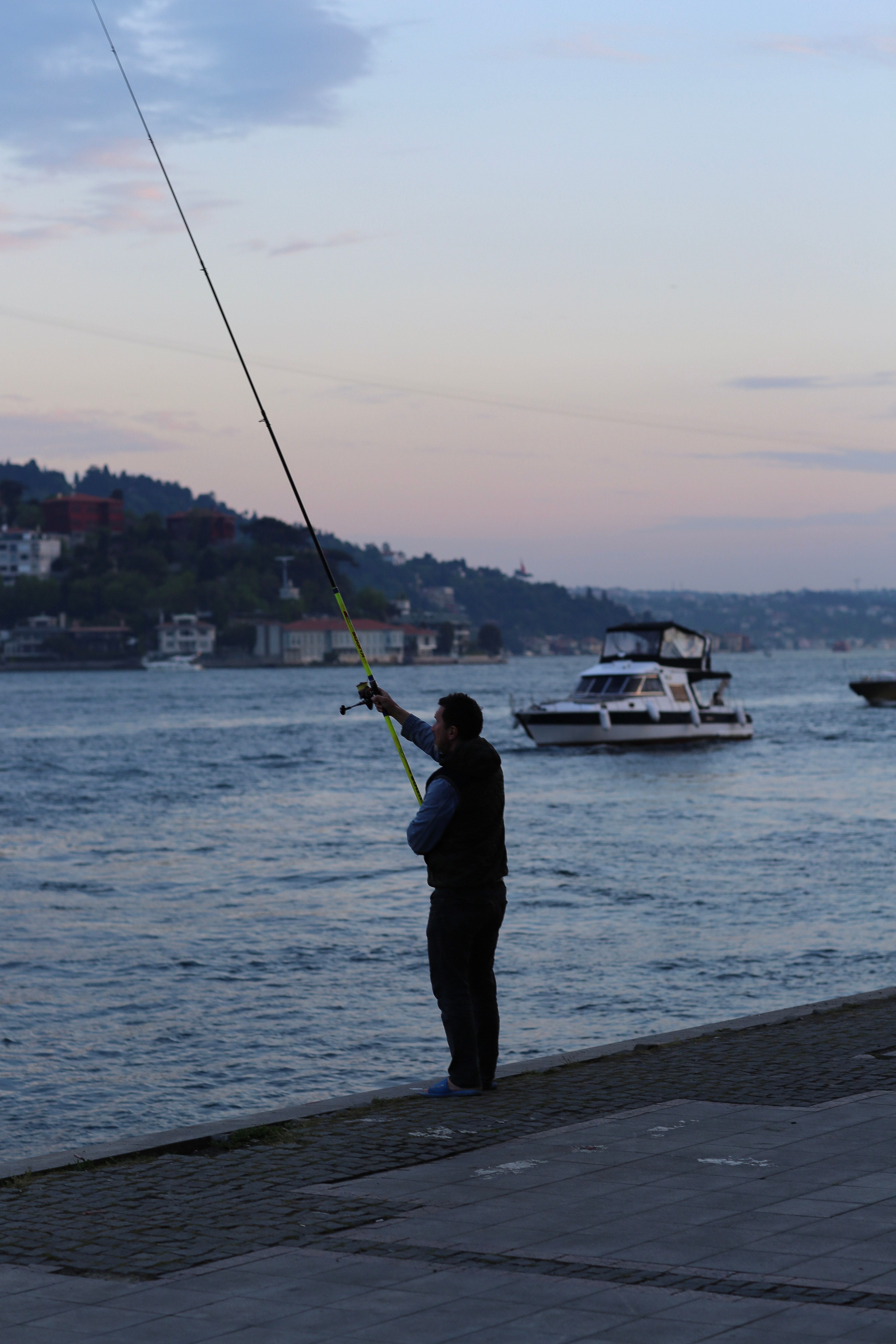 Man Fishing on Shallow Waters of the Beach Against the Light Photo ...