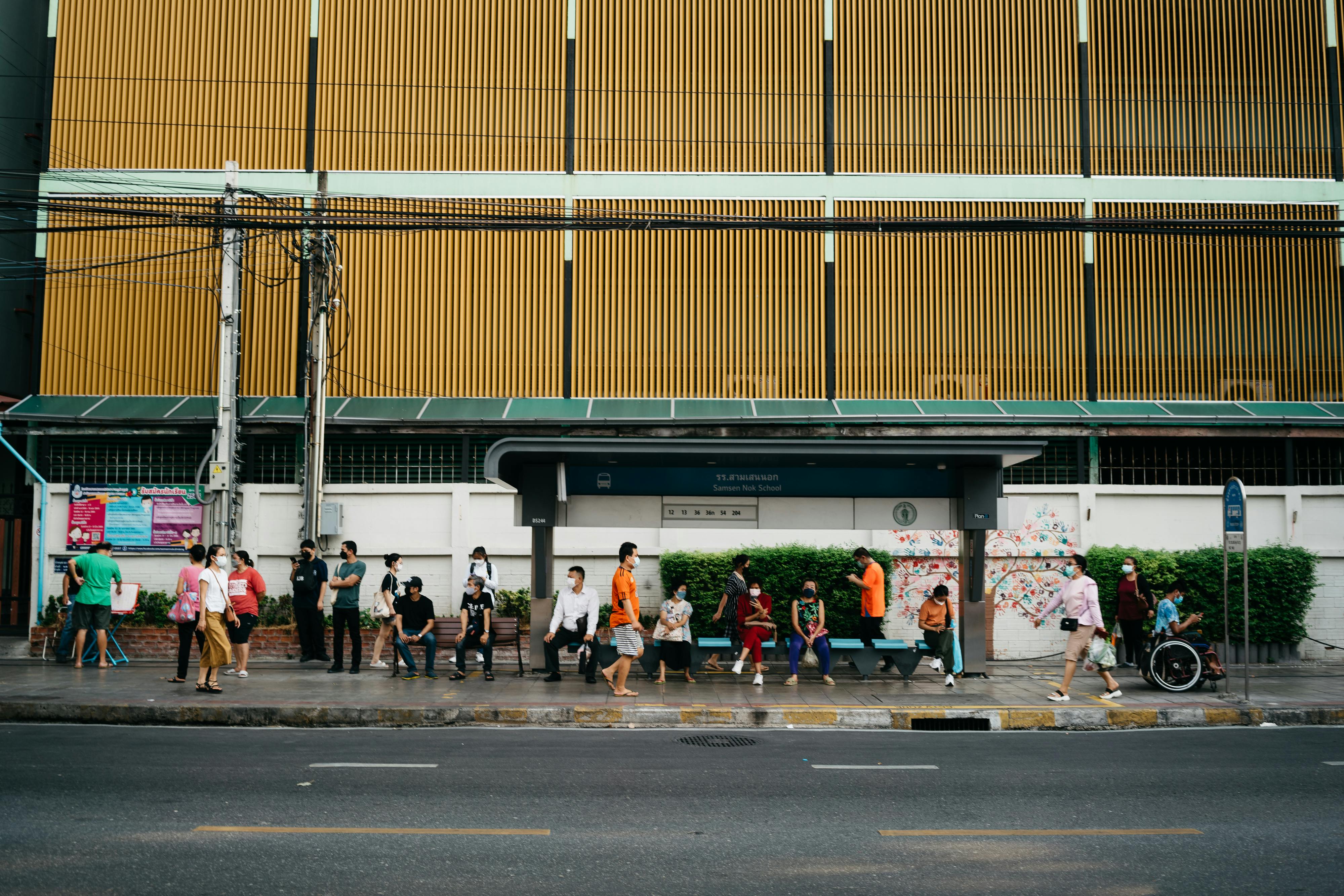 People Walking on a Sidewalk and Waiting at a Bus Stop · Free Stock Photo