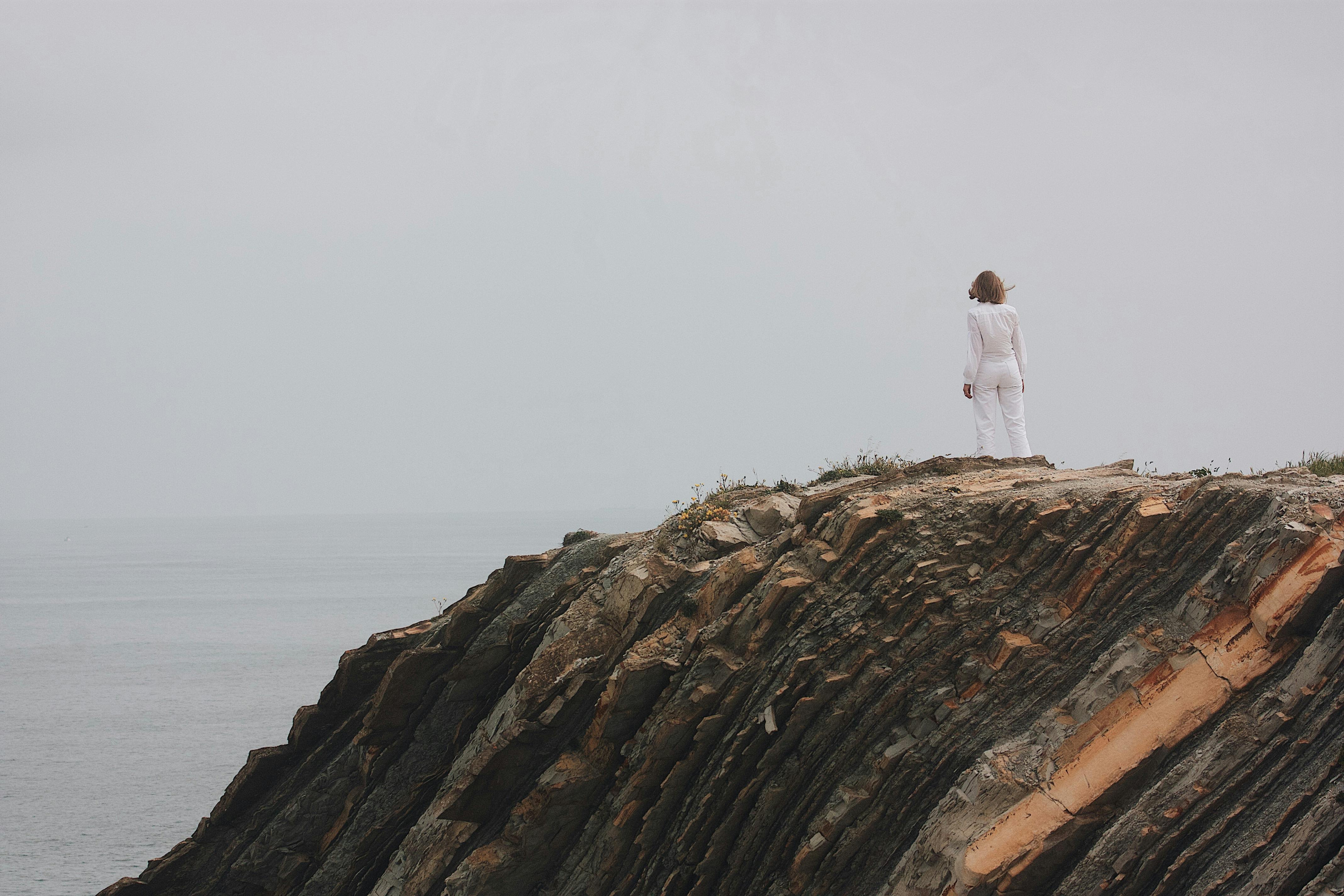 Back View of a Woman on a Cliff · Free Stock Photo
