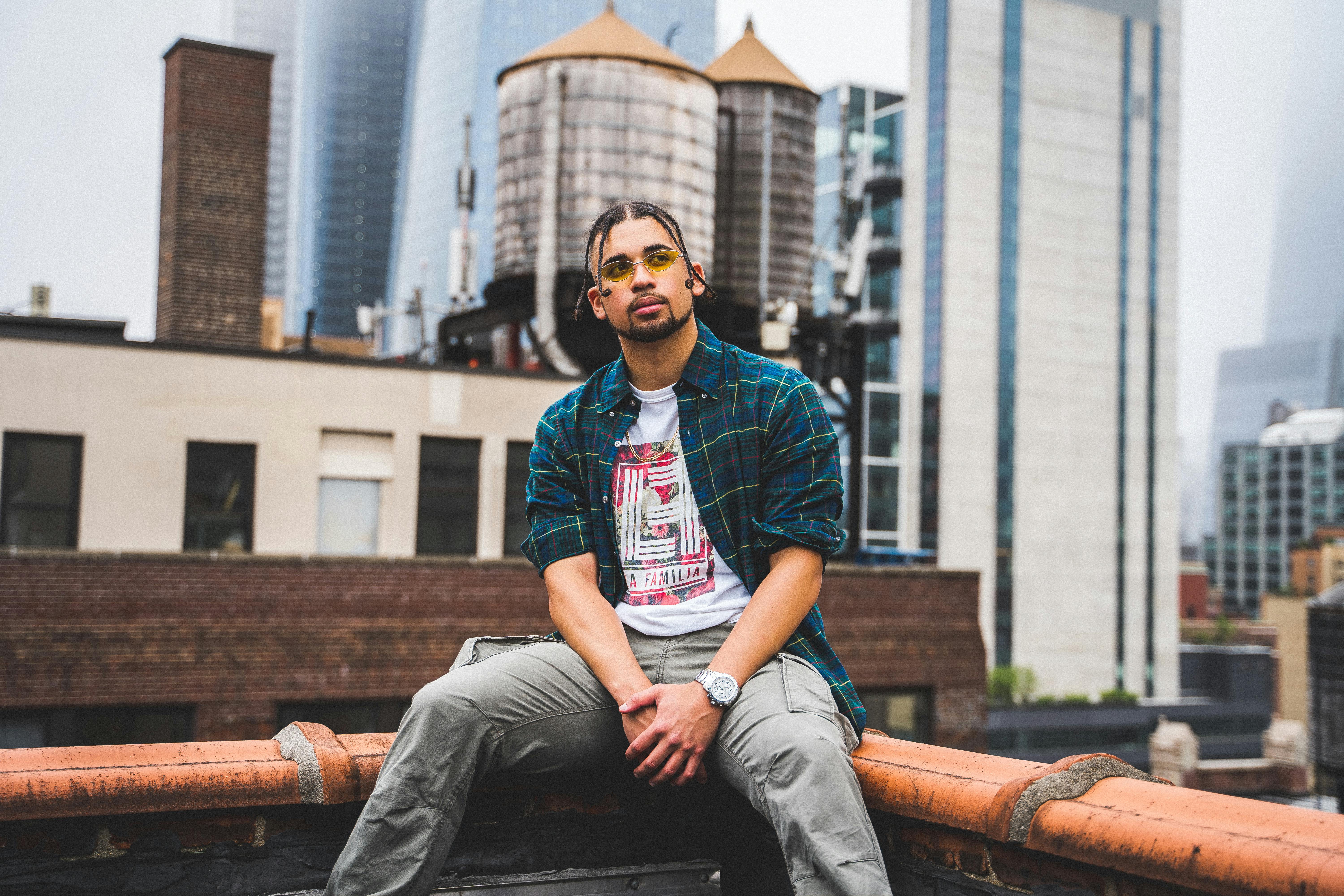 Man Sitting on the Roof of a Building · Free Stock Photo