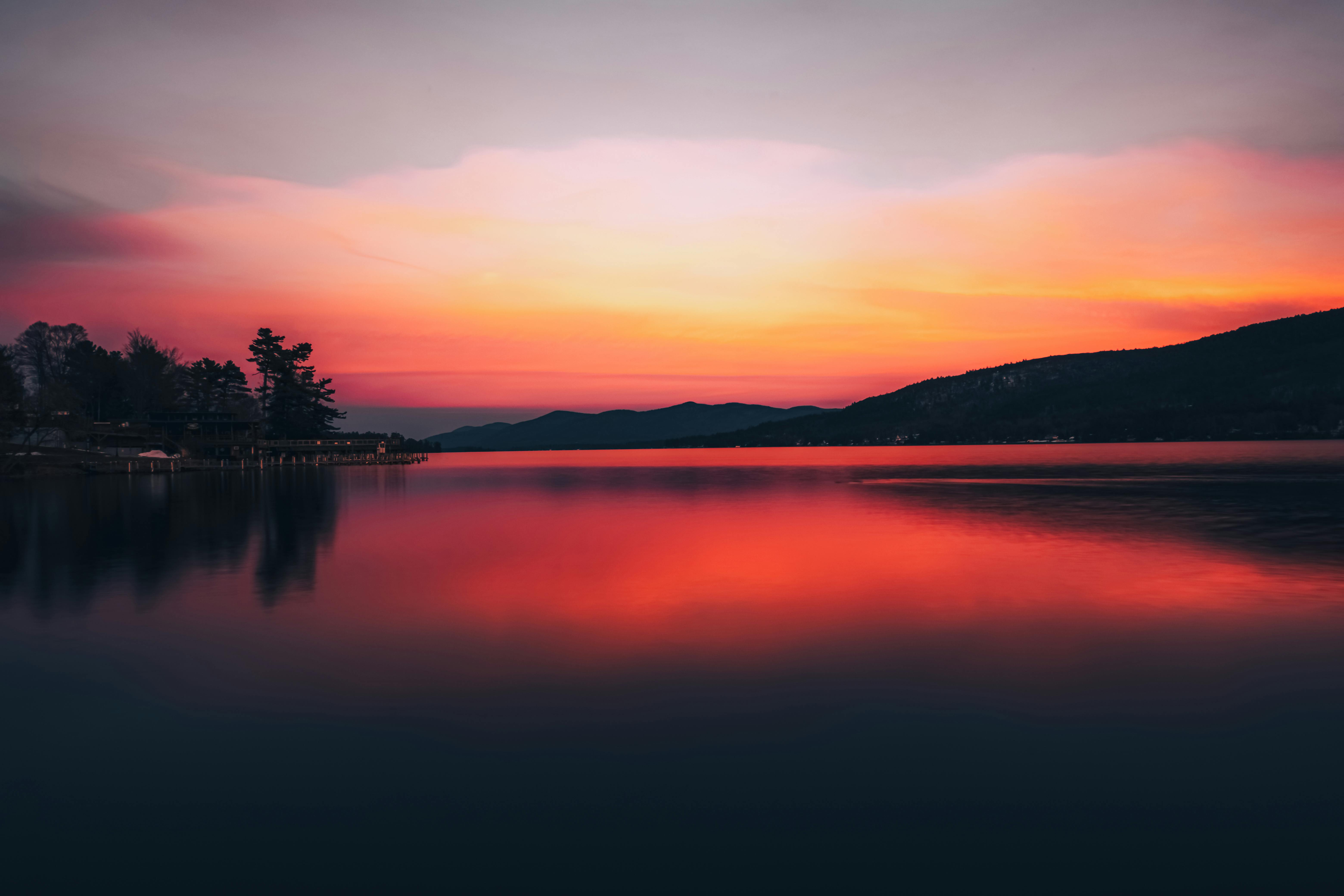 Silhouette of Trees Near Body of Water during Sunset · Free Stock Photo