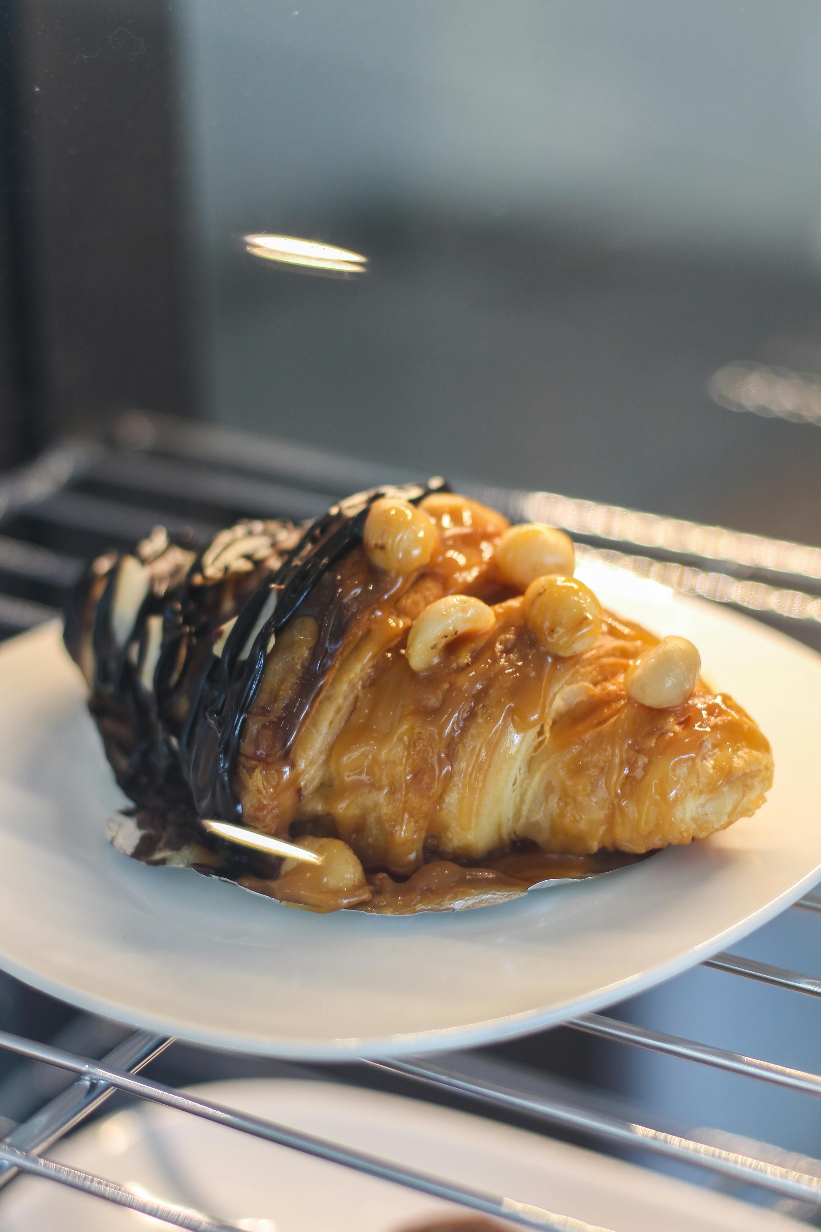 A Croissant With Chocolate and Caramel Syrup · Free Stock Photo