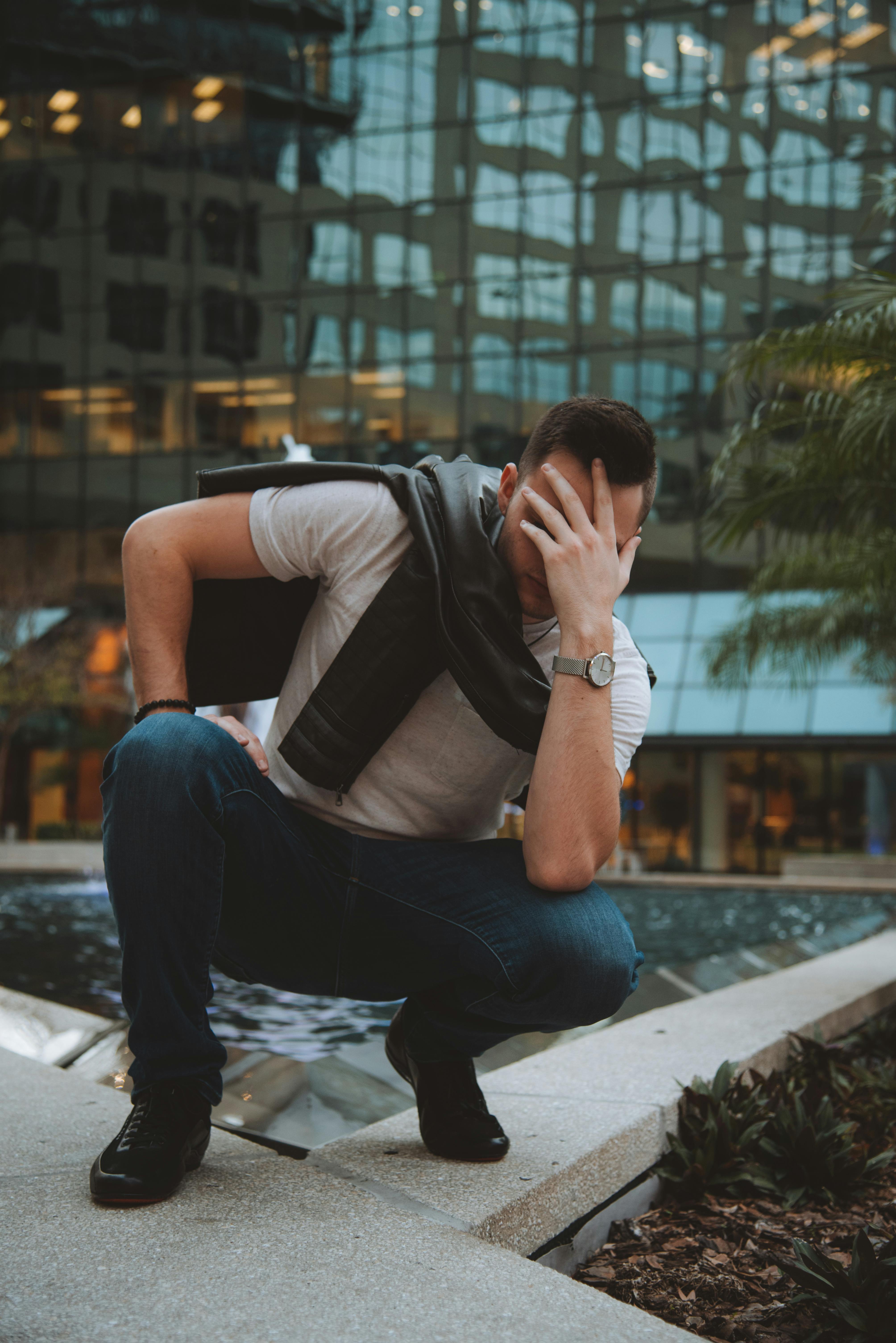 A Man Crouching Near the Pool · Free Stock Photo