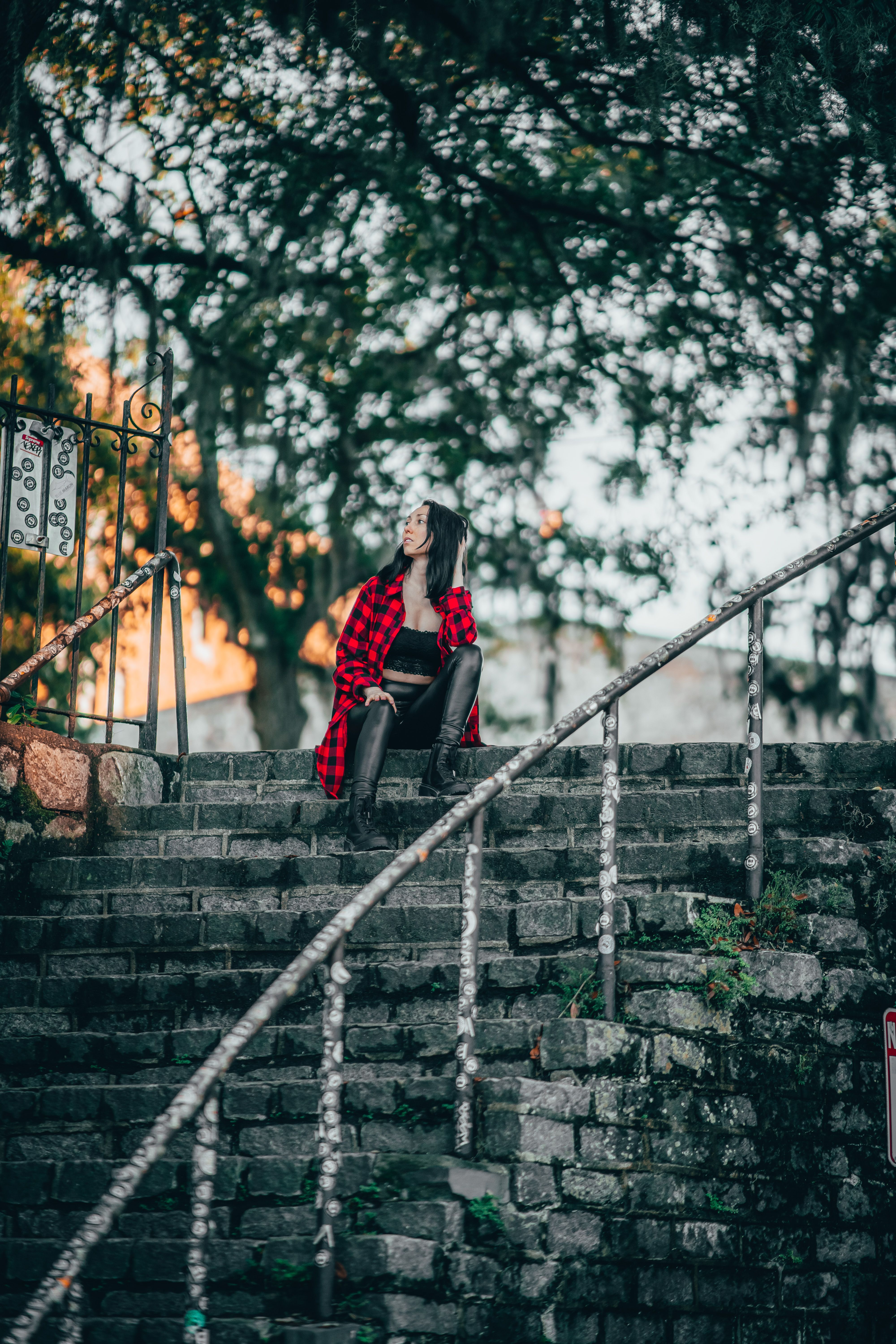 Young Woman Sitting on the Steps by the Sea and Showing Victory Gesture ...