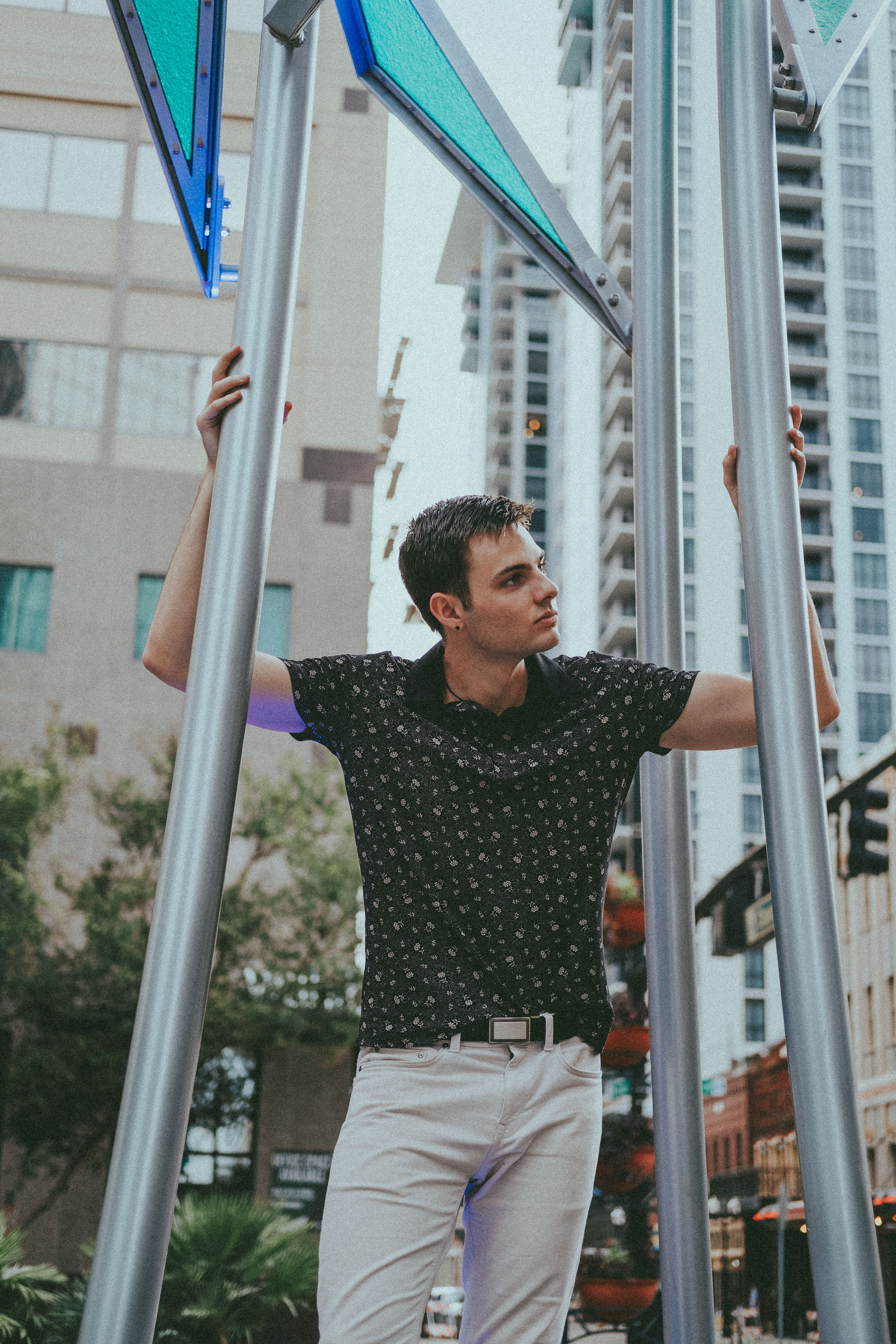 Young Man Standing between Metal Poles · Free Stock Photo