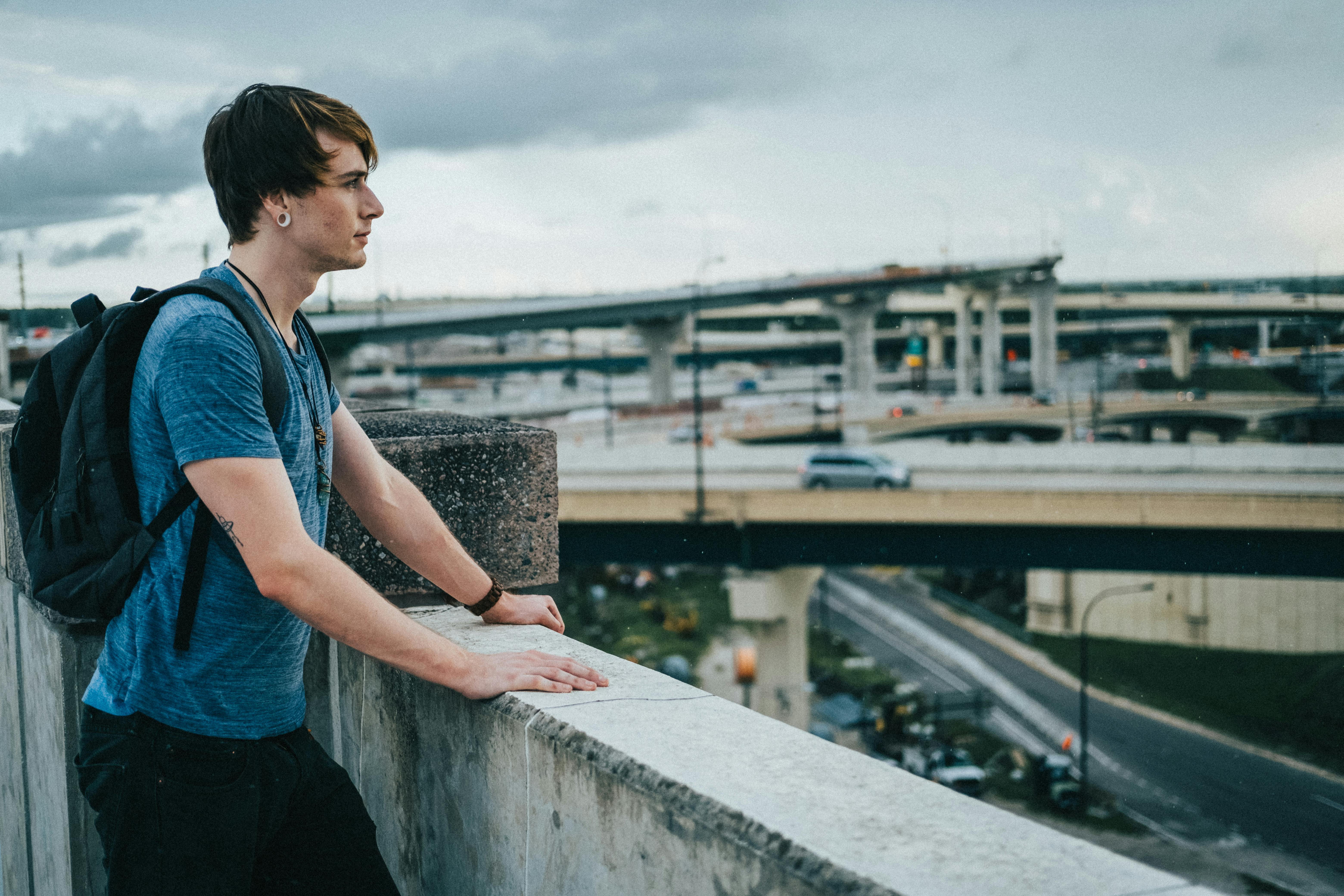 Guy Standing on Bridge near Highway · Free Stock Photo