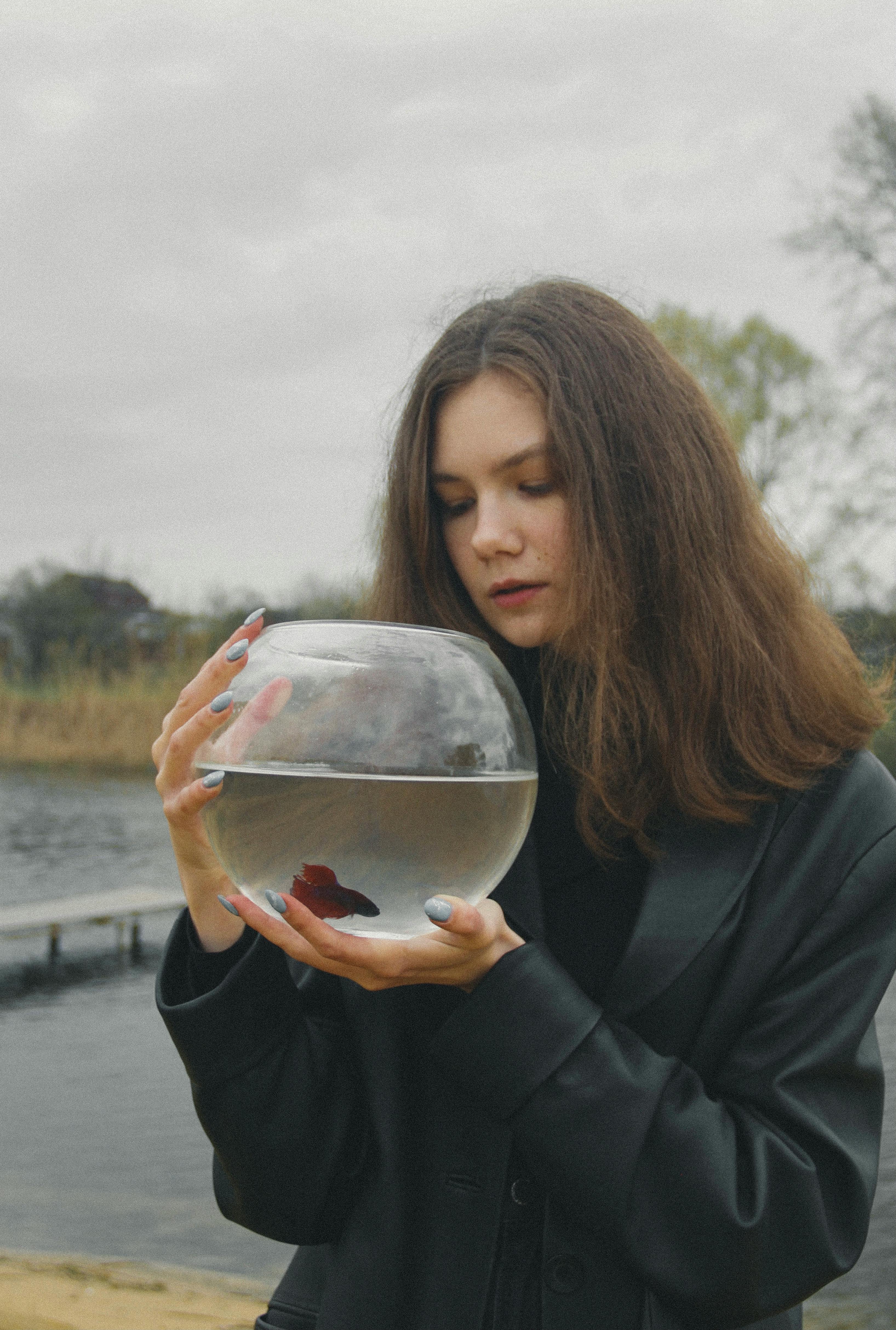 Girl Looking a Fishbowl in her Hands · Free Stock Photo