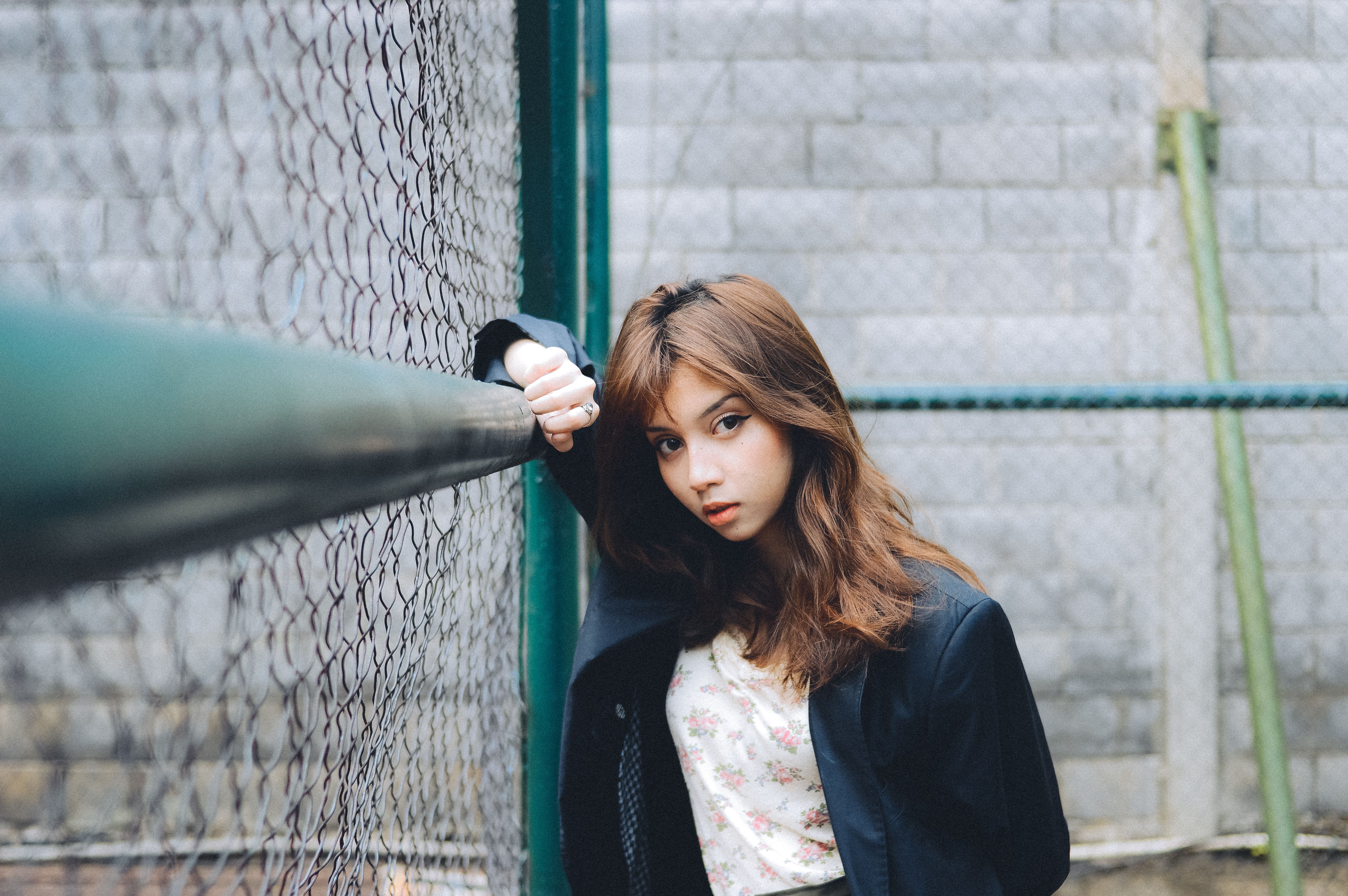 Young Woman in a Theatrical Pose Holding to Wire Mesh on a Footbridge ...