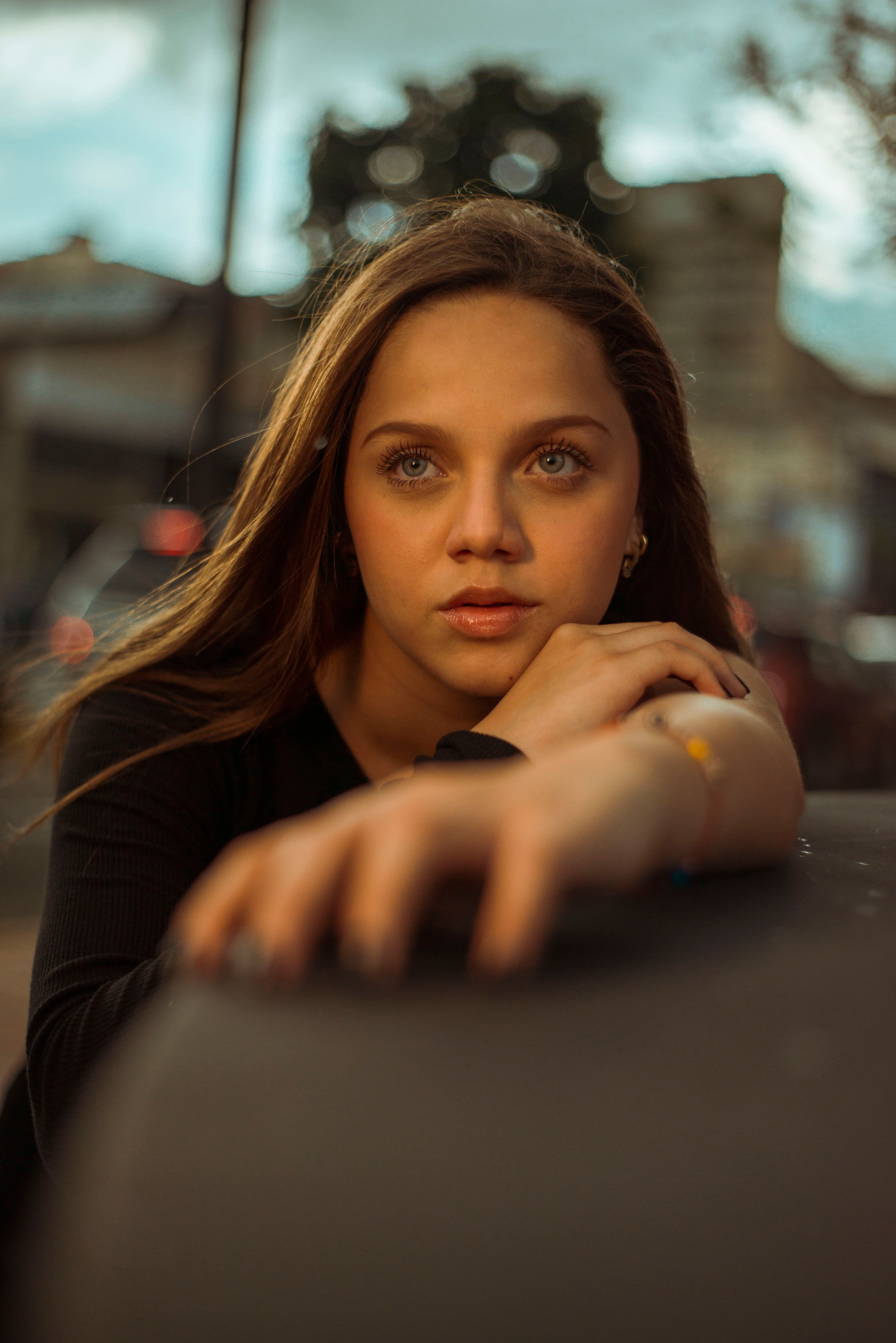 Portrait of a Young Woman Resting her Arm on a Table · Free Stock Photo