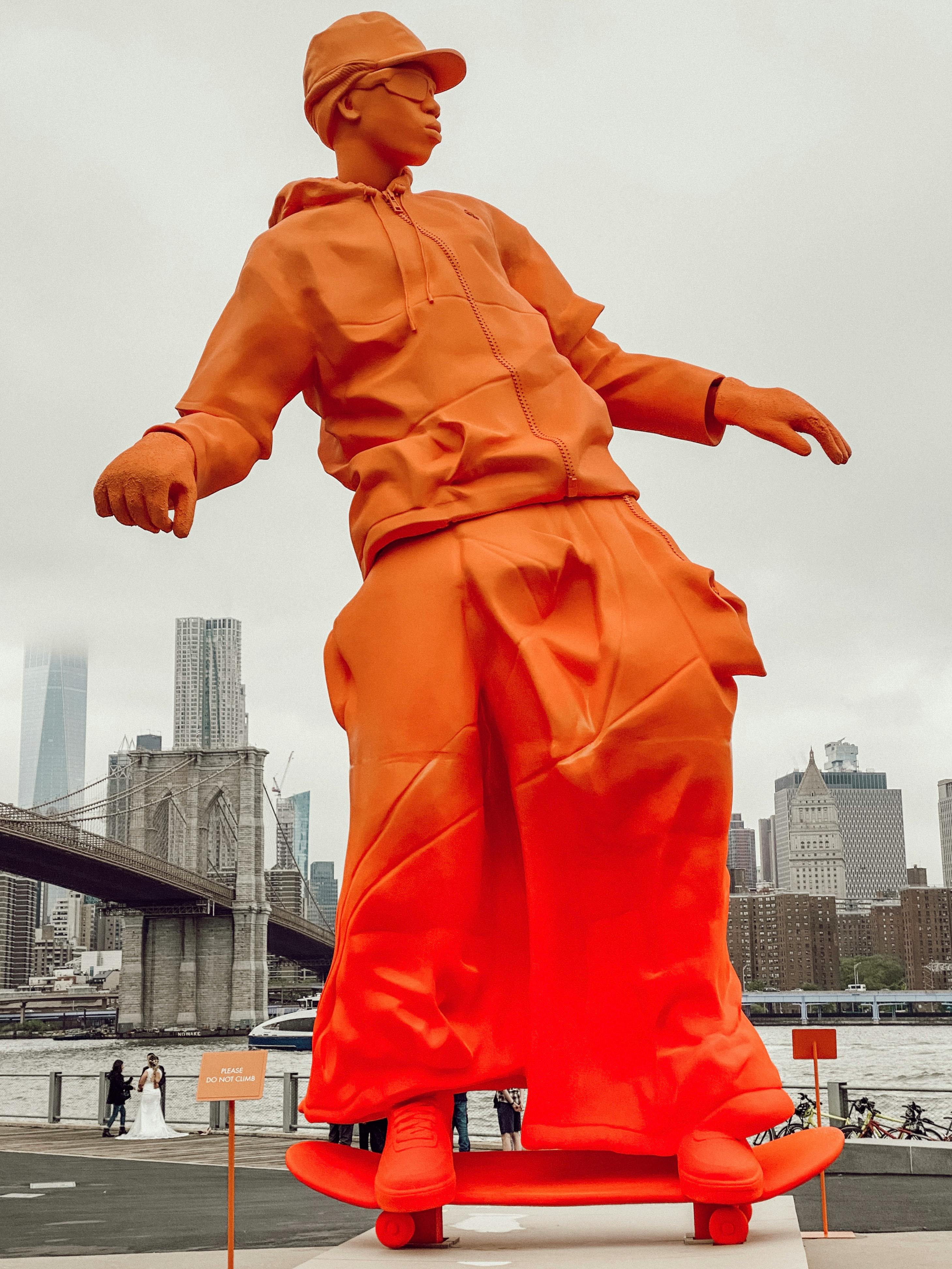 A Giant Orange Statue of a Skateboarder in Brooklyn Bridge Park, New ...