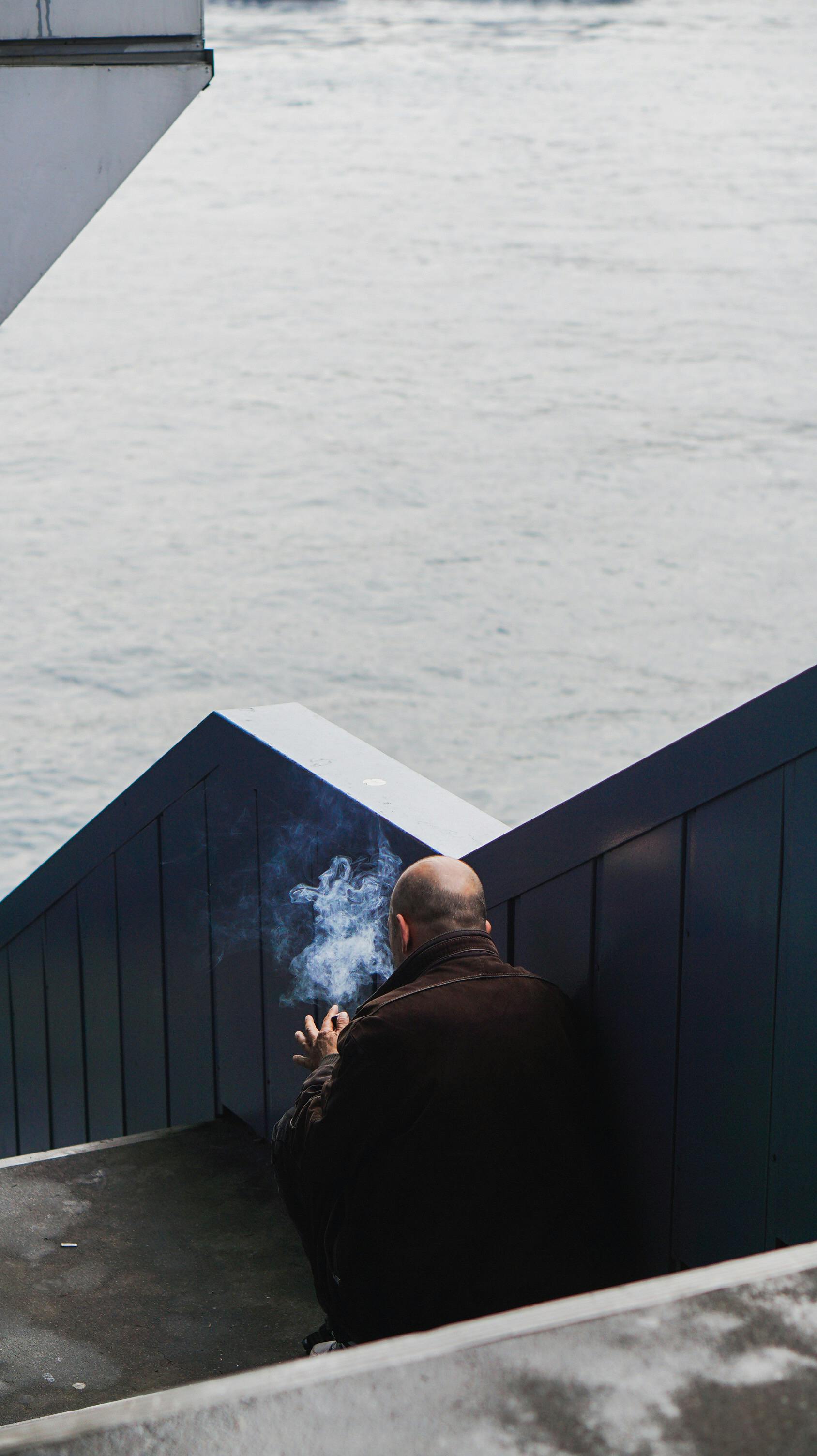 Man Sitting on Stairs Outside and Smoking a Cigarette · Free Stock Photo