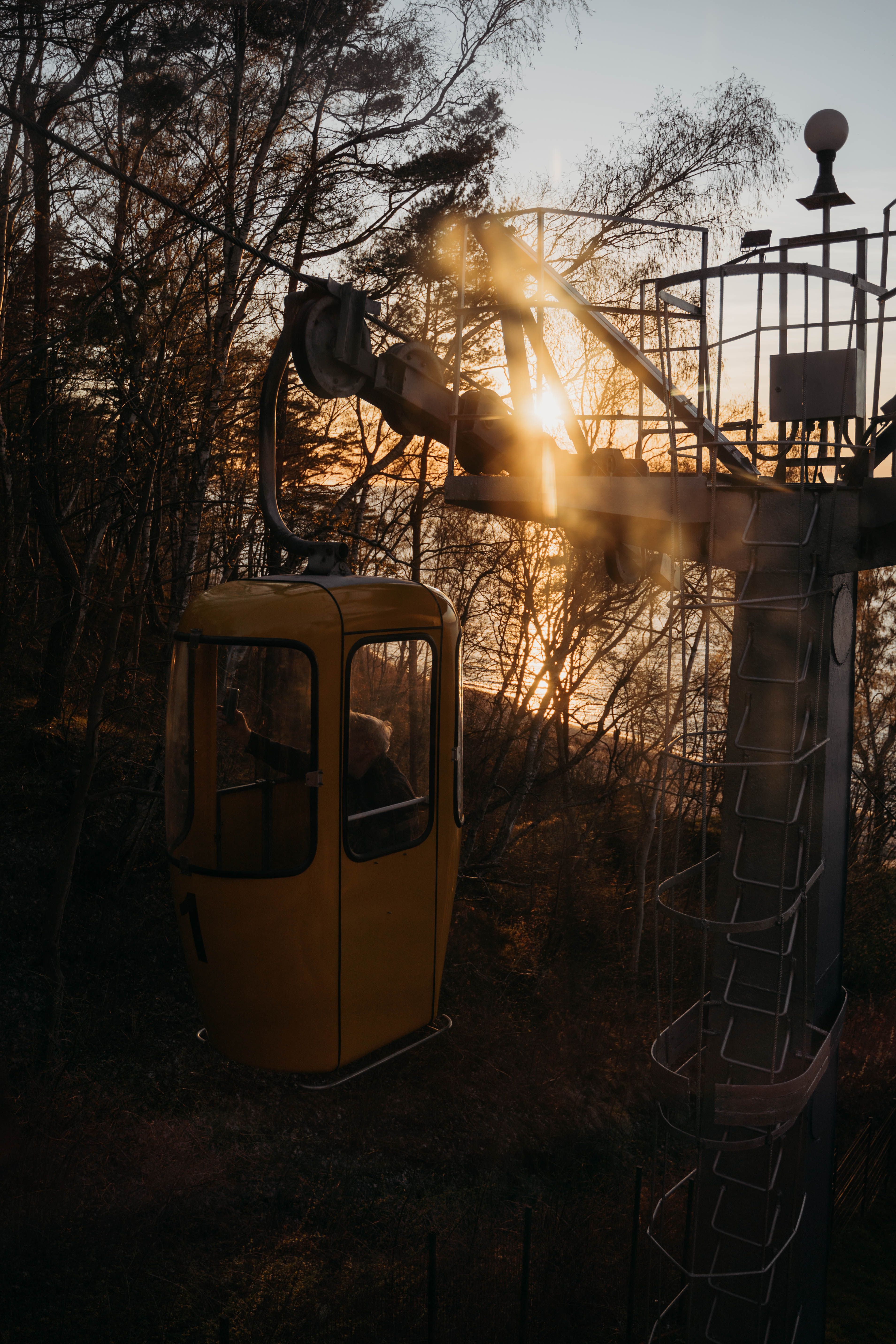 A Person Riding a Yellow Cable Car · Free Stock Photo