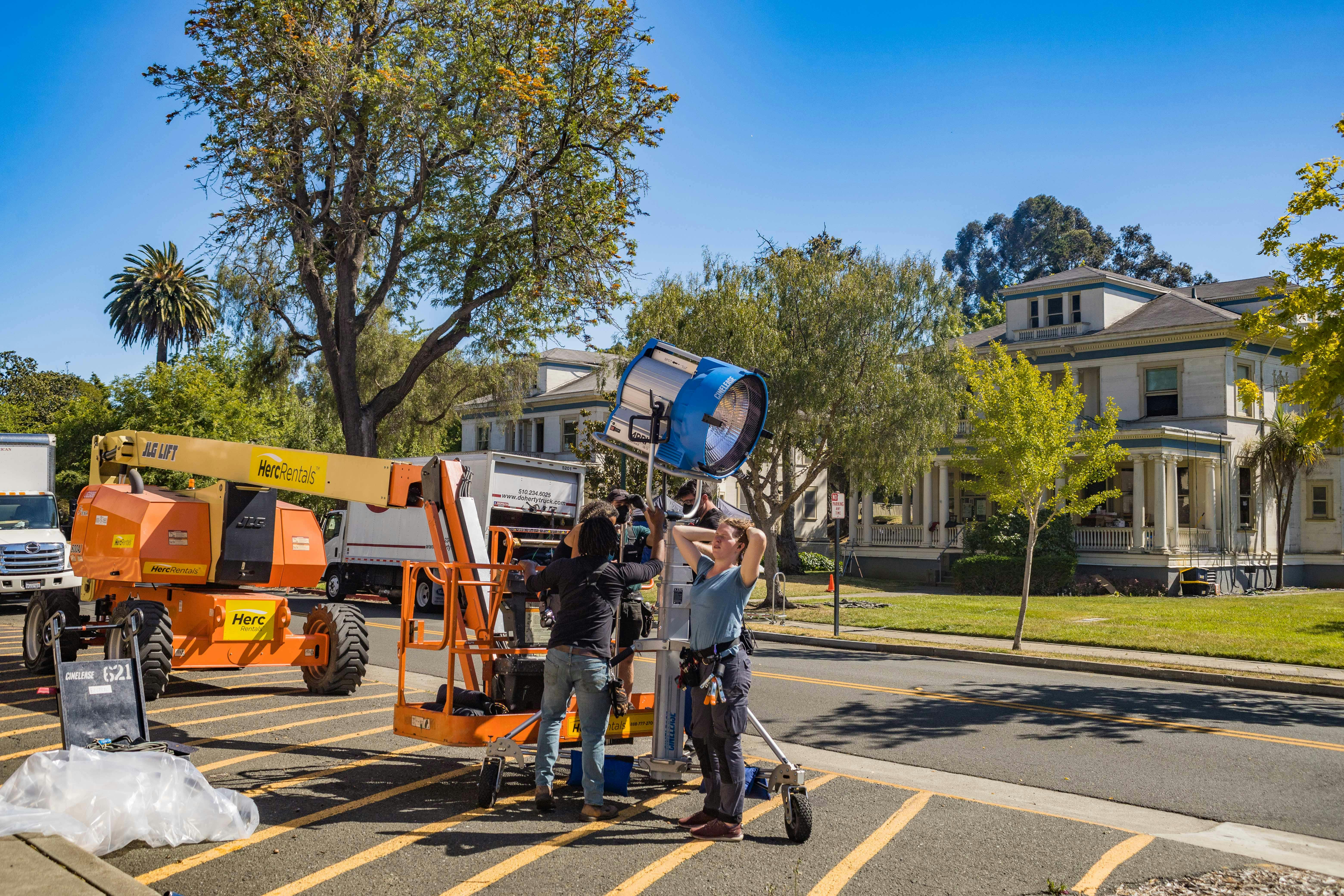 Crew setting-up a Spotlight on a Roadside · Free Stock Photo