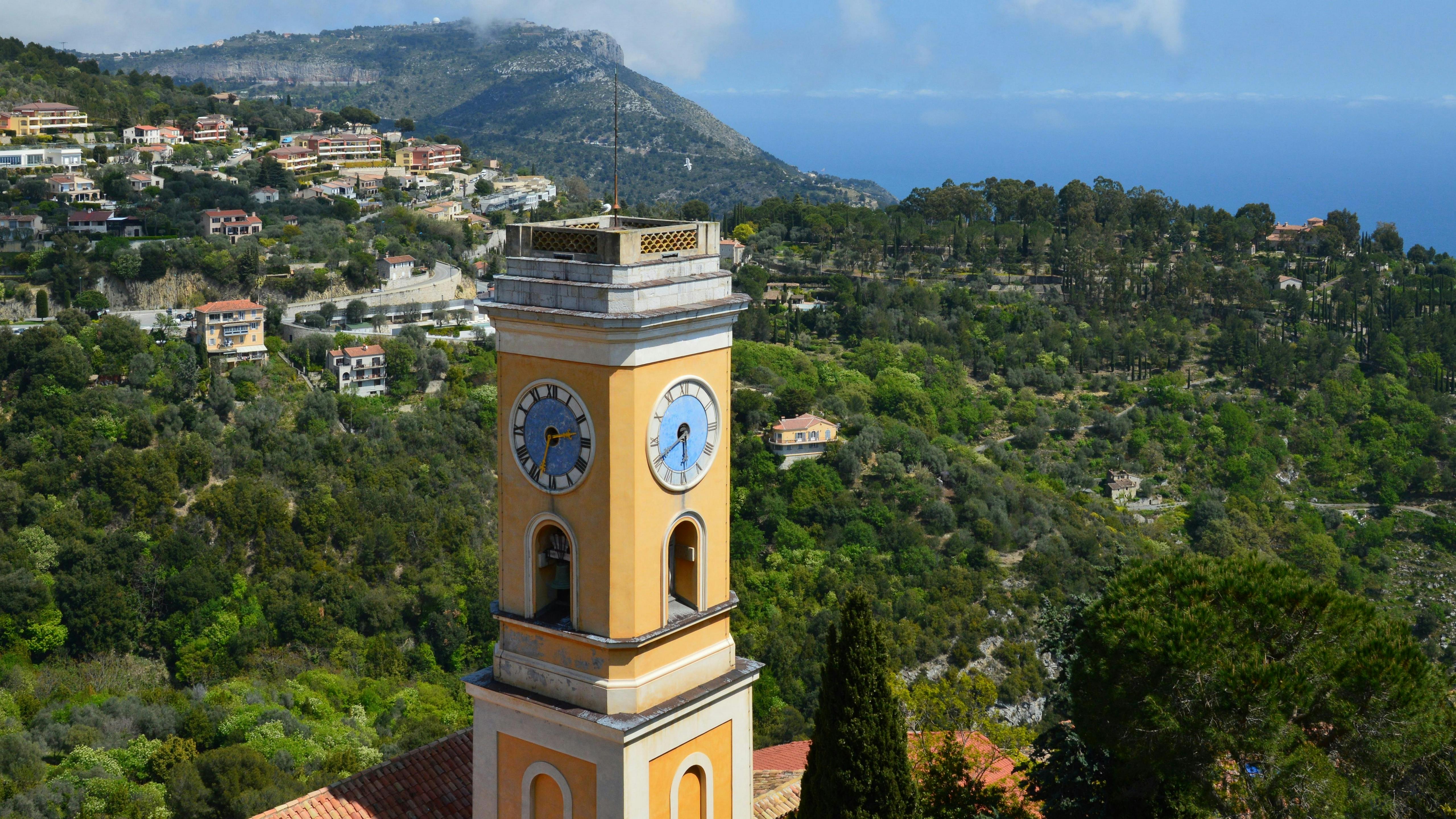 A Yellow Concrete Clock Tower Near Green Trees on a Mountain · Free ...