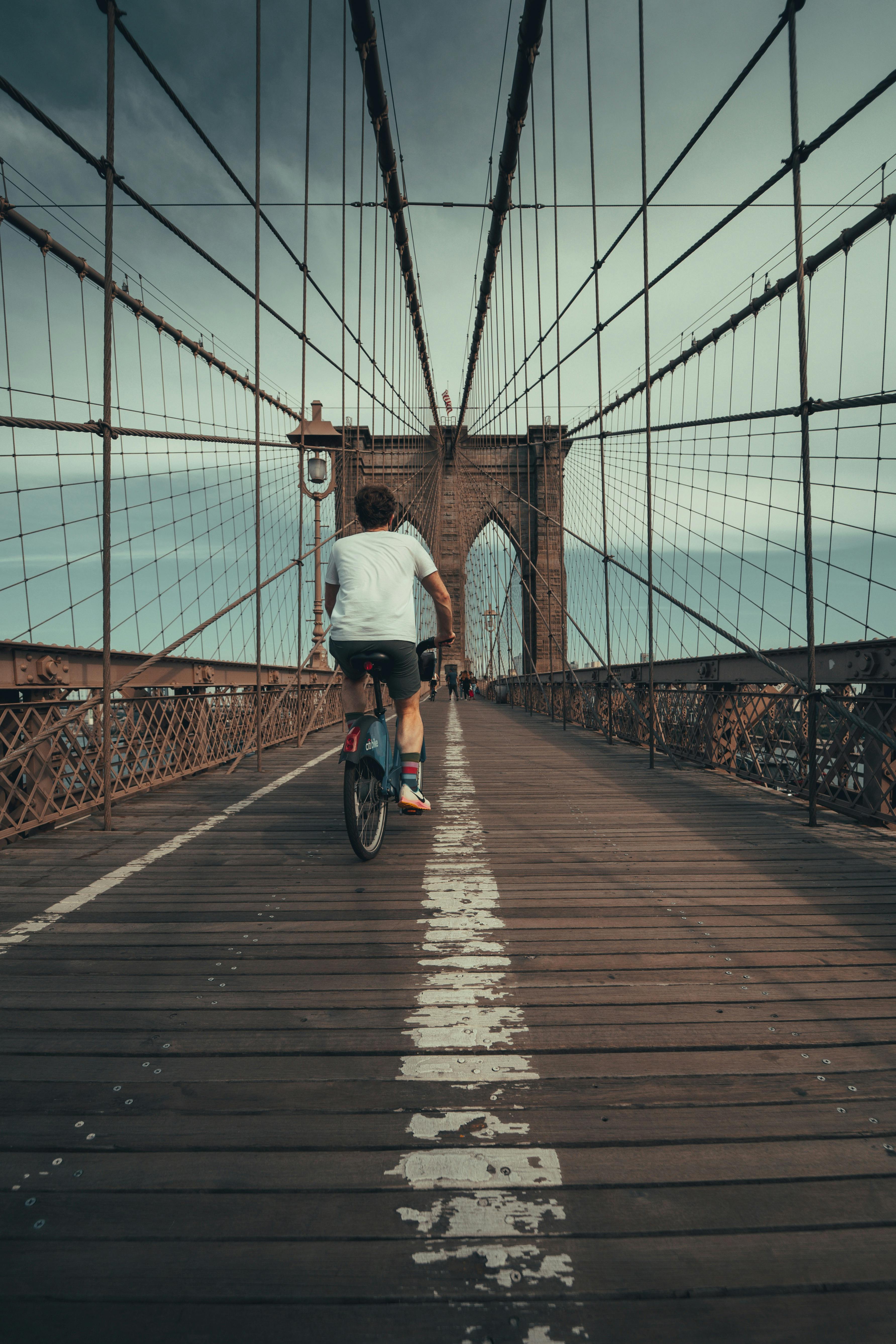 Person Riding a Bicycle Across The Brooklyn Bridge · Free Stock Photo