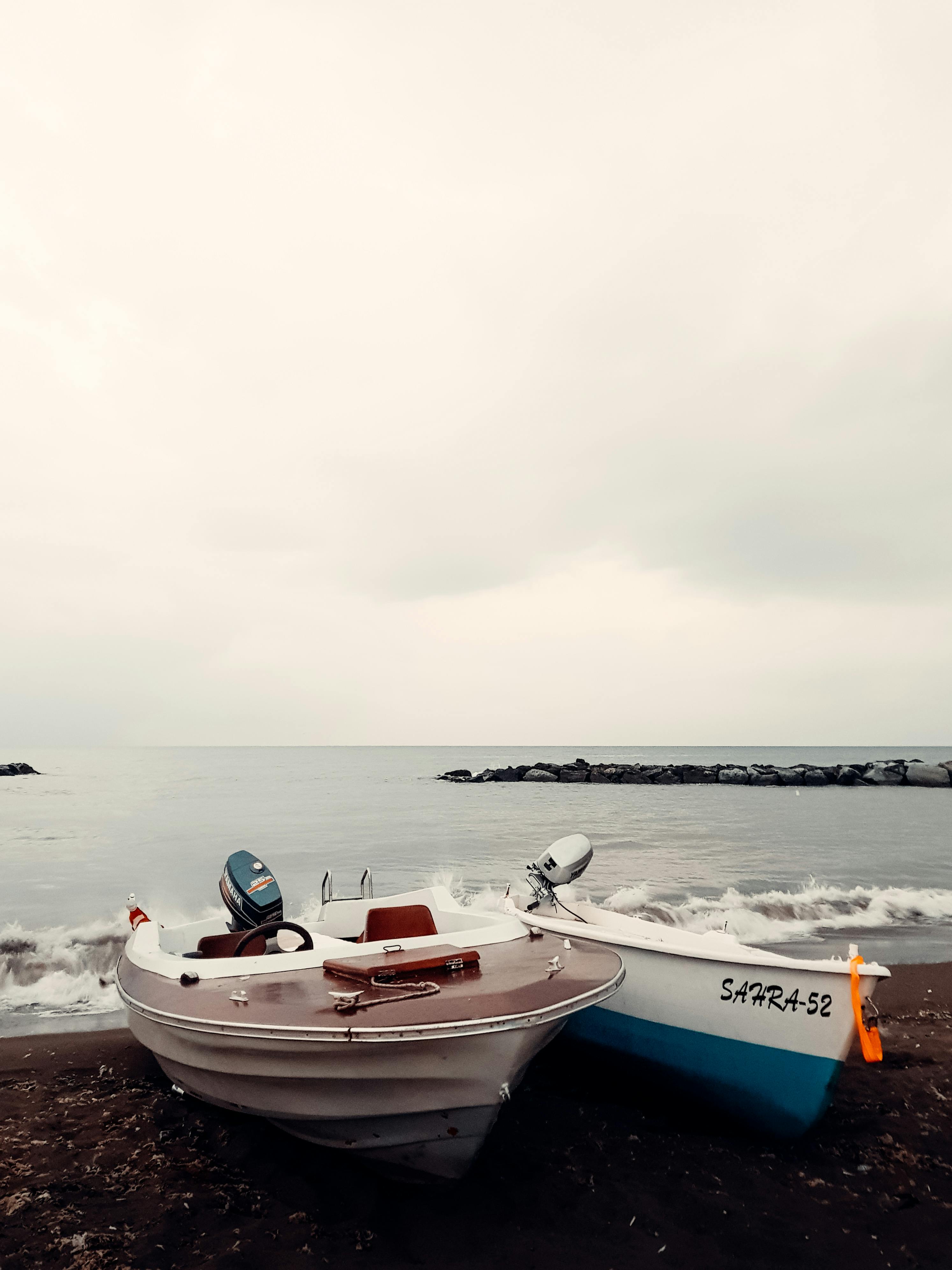 Rain Cloud over Empty Motorboat on Beach at Sunset · Free Stock Photo