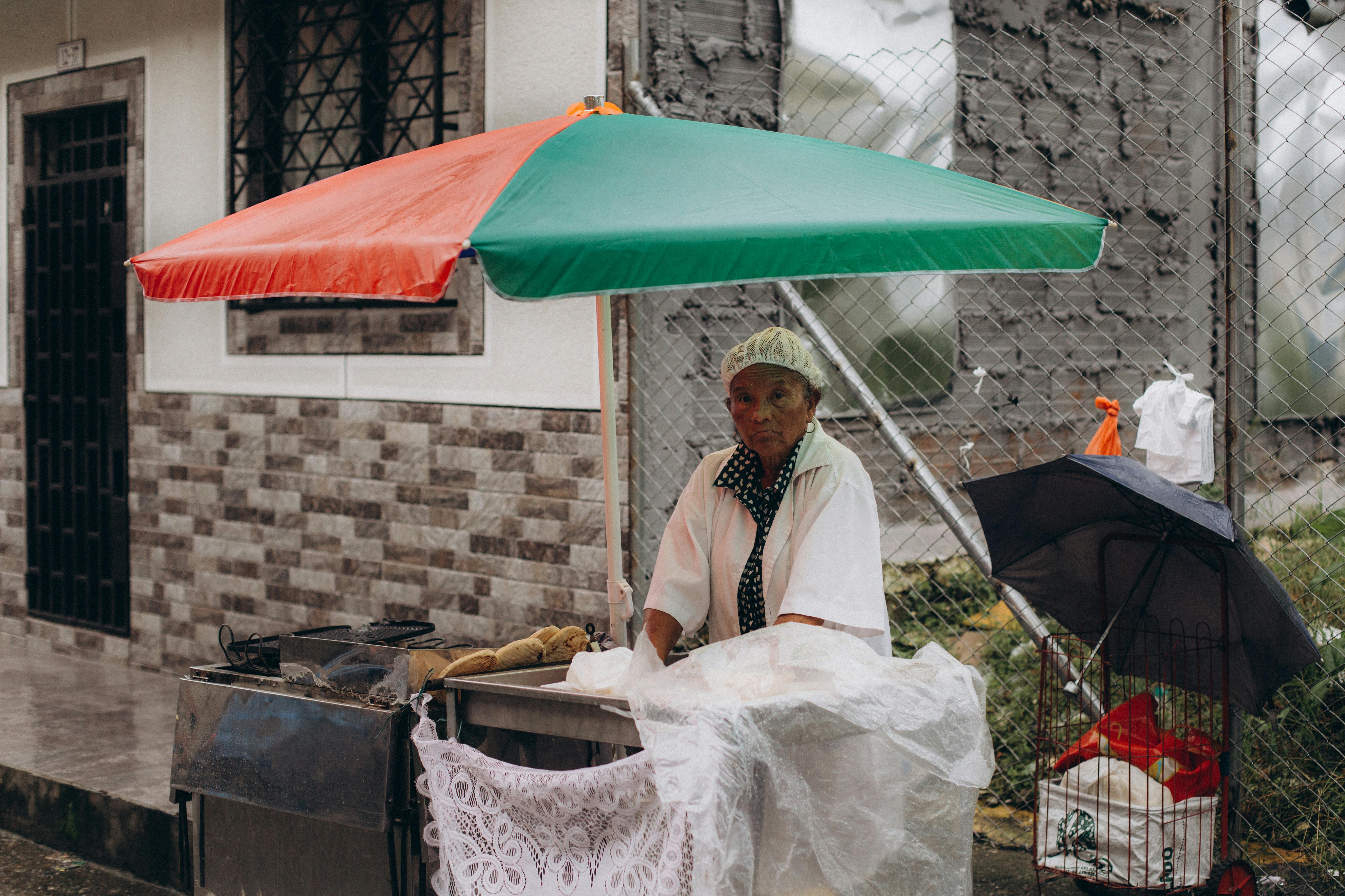 Vendor Standing on Street Side · Free Stock Photo