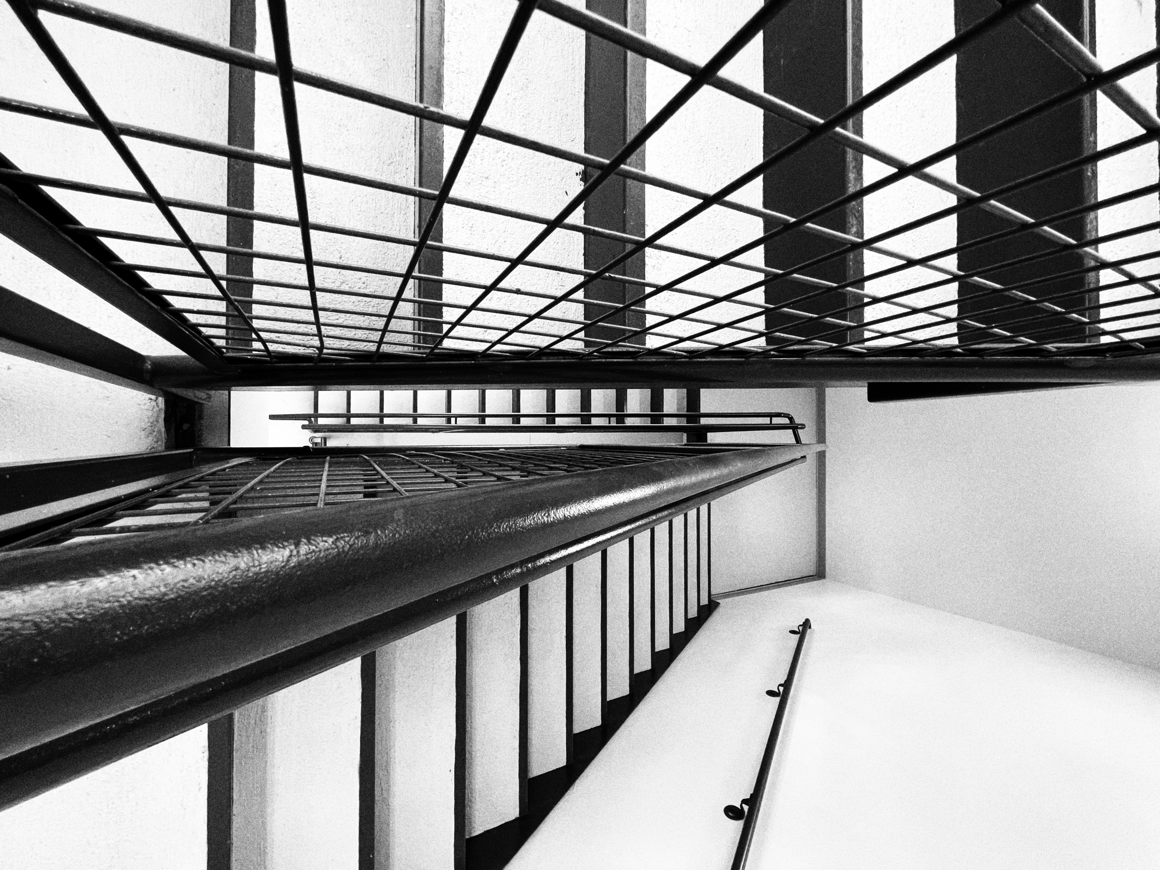 Grayscale Photo of People Walking through Steel Trusses · Free Stock Photo