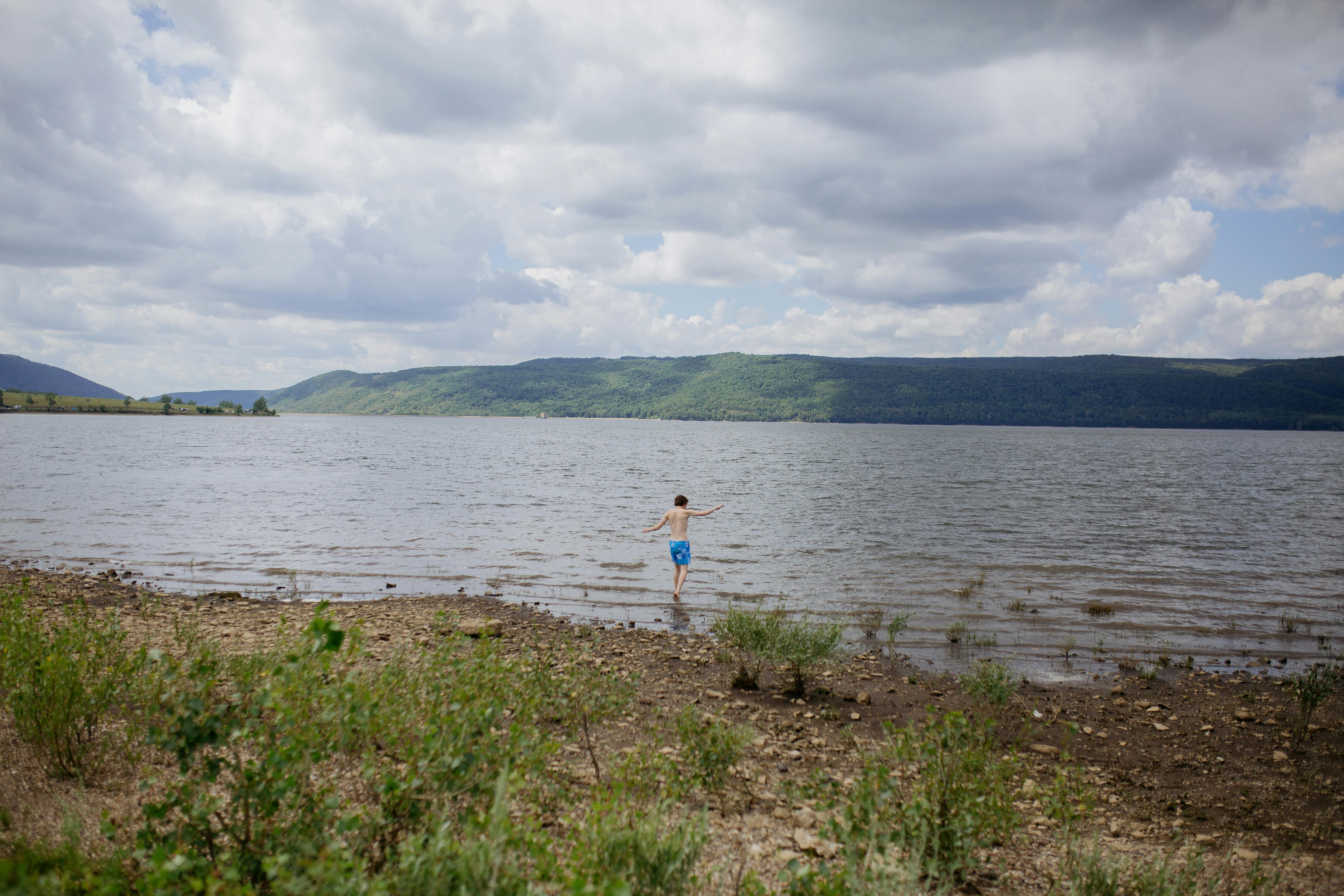 Back View of a Boy Entering a Lake · Free Stock Photo