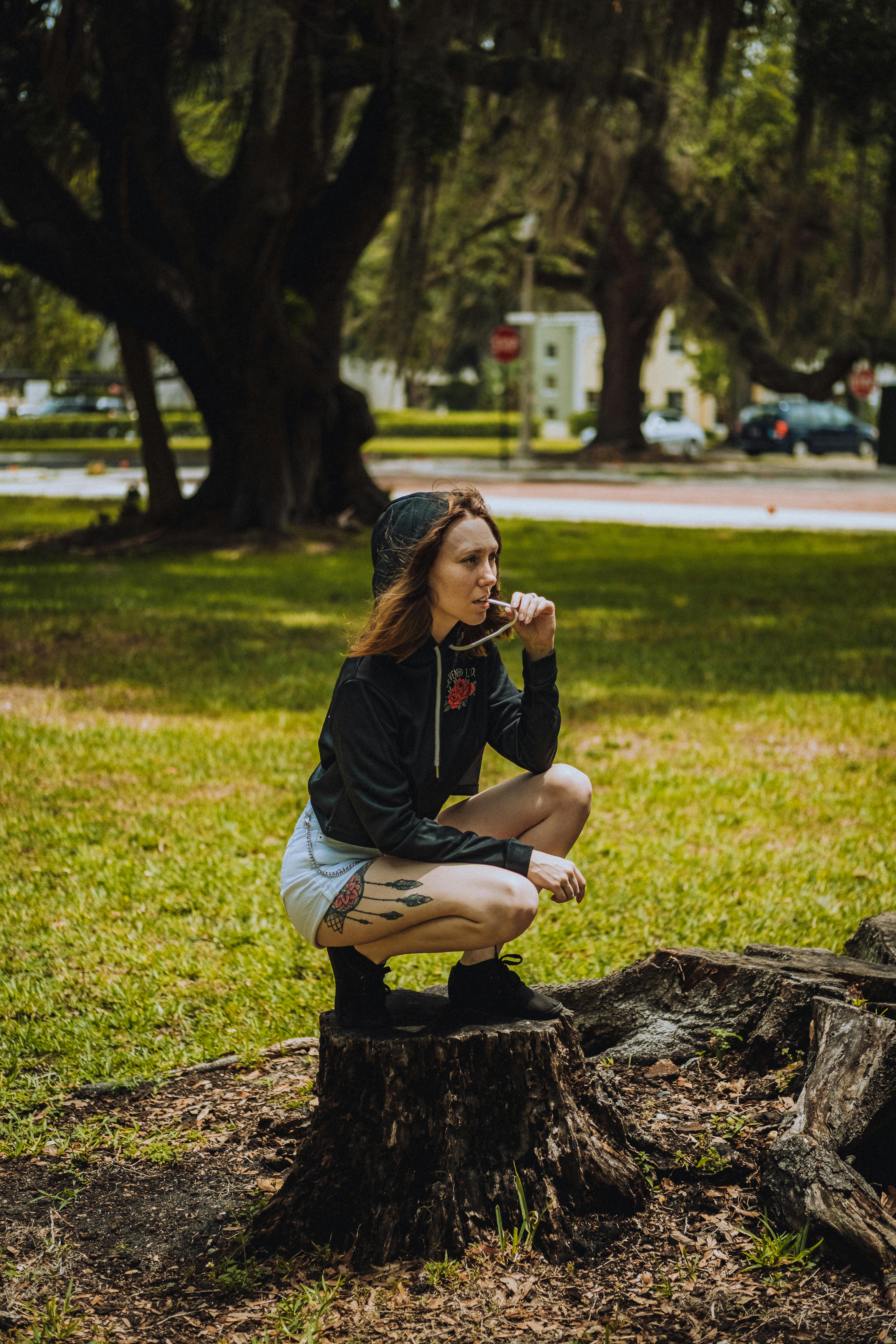 Stylish Woman sitting on a Tree Stump · Free Stock Photo