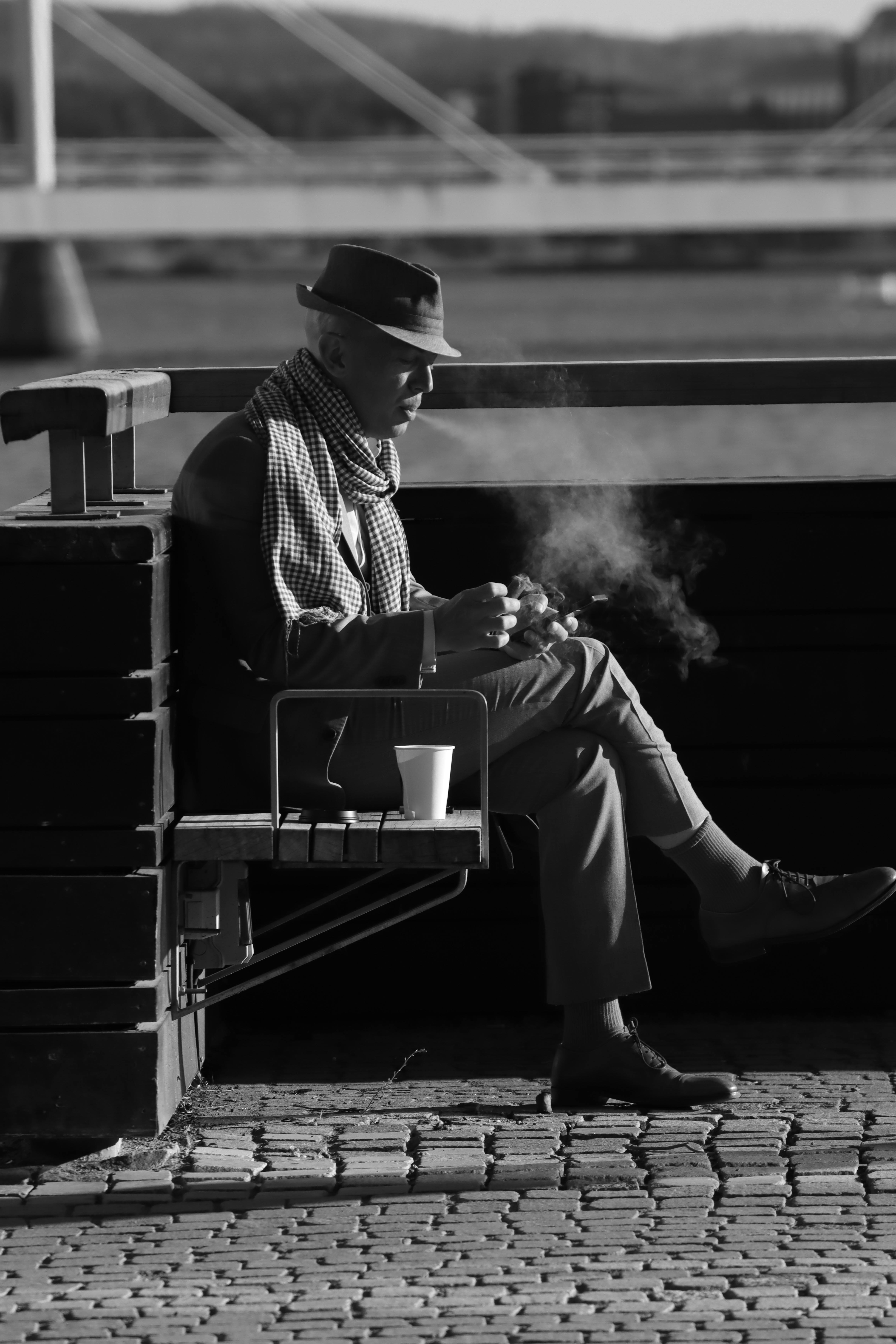 Grayscale Photo of a Man Sitting on Bench Smoking · Free Stock Photo