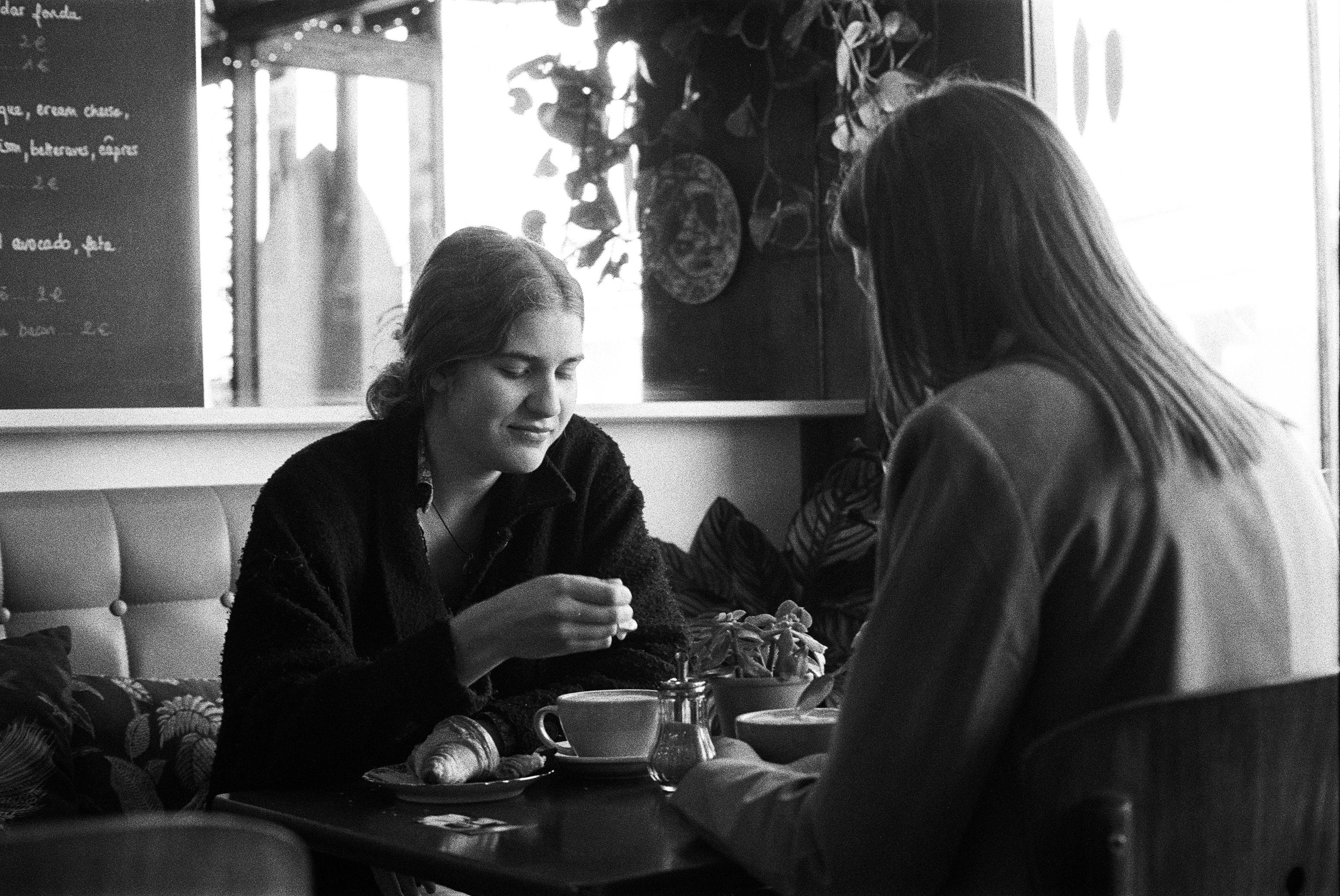 Grayscale Photo of Two Women Having Coffee Together · Free Stock Photo