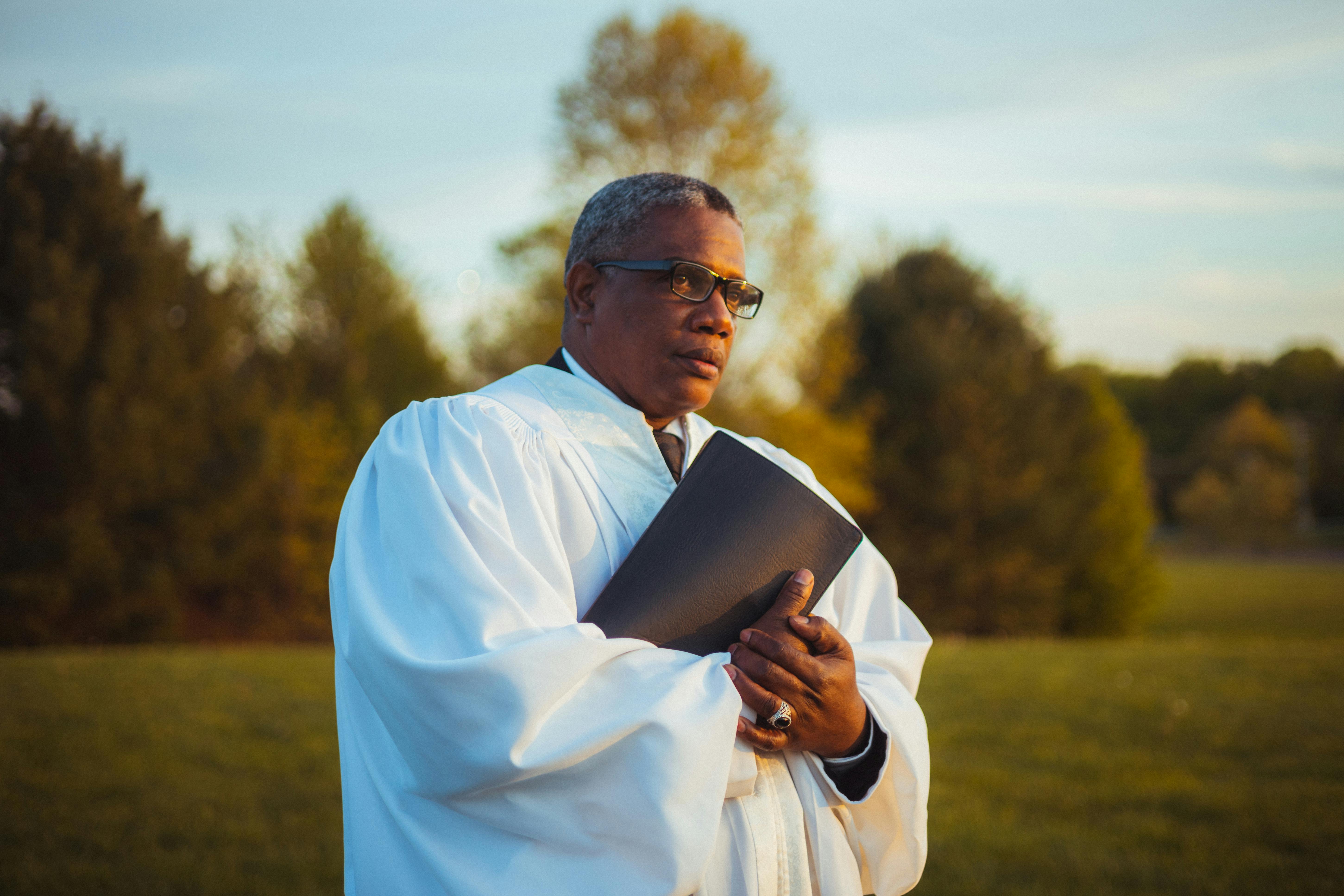 Priest Holding a Book · Free Stock Photo