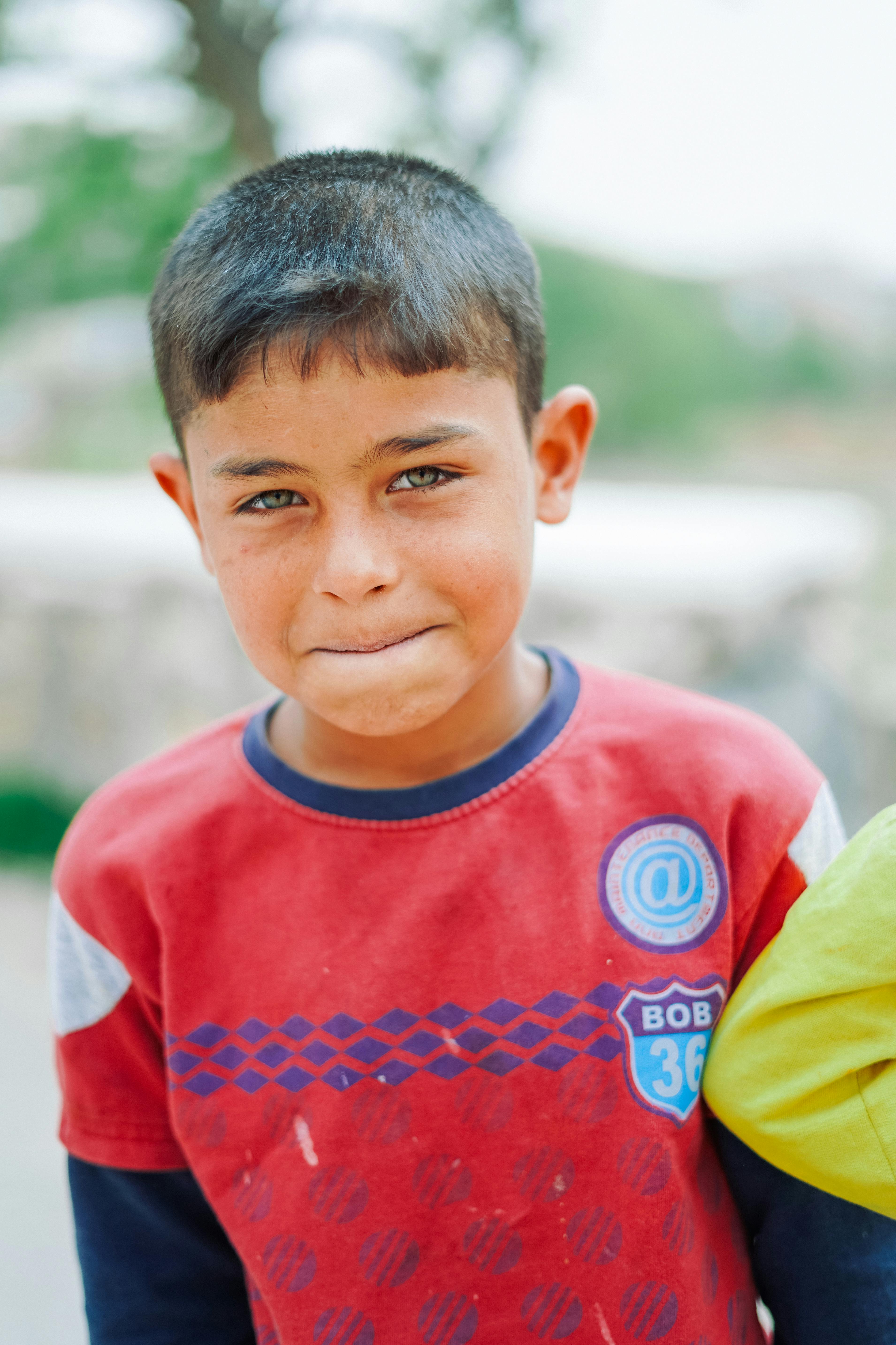 Smiling Boy Face behind Leaves · Free Stock Photo