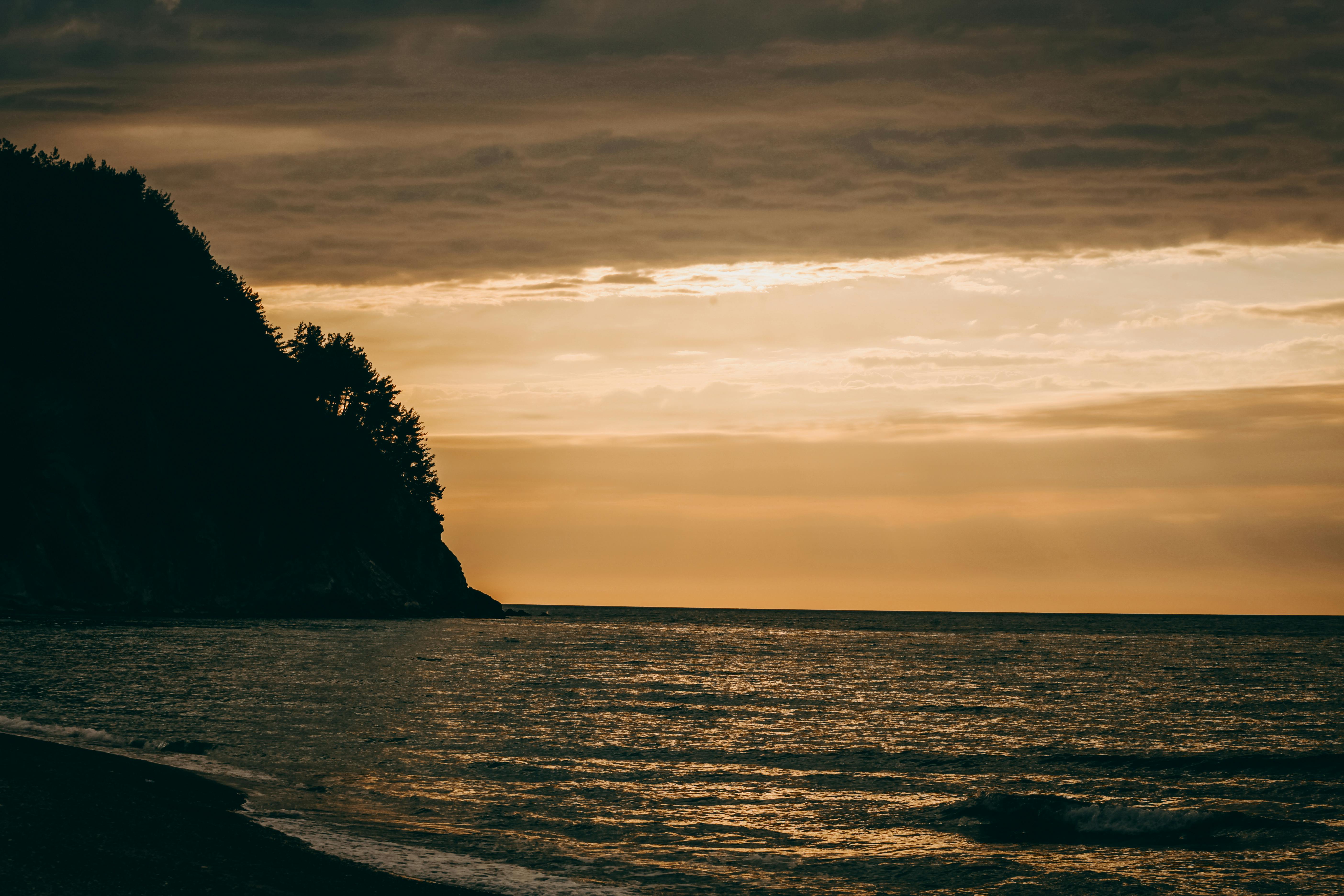 Beach and Cliffs at Sunset · Free Stock Photo