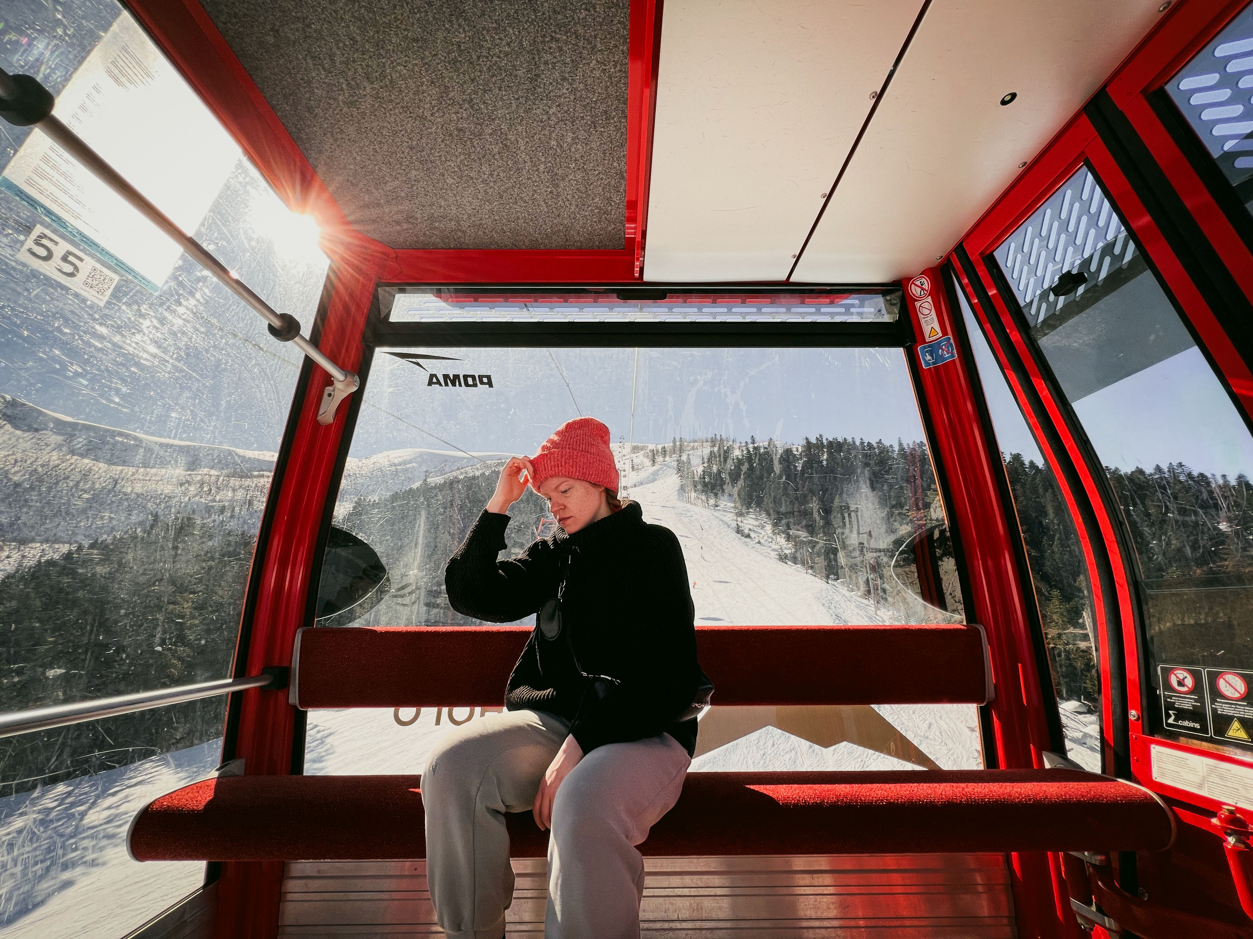 Woman Sitting inside a Ski Lift above a Ski Slope · Free Stock Photo