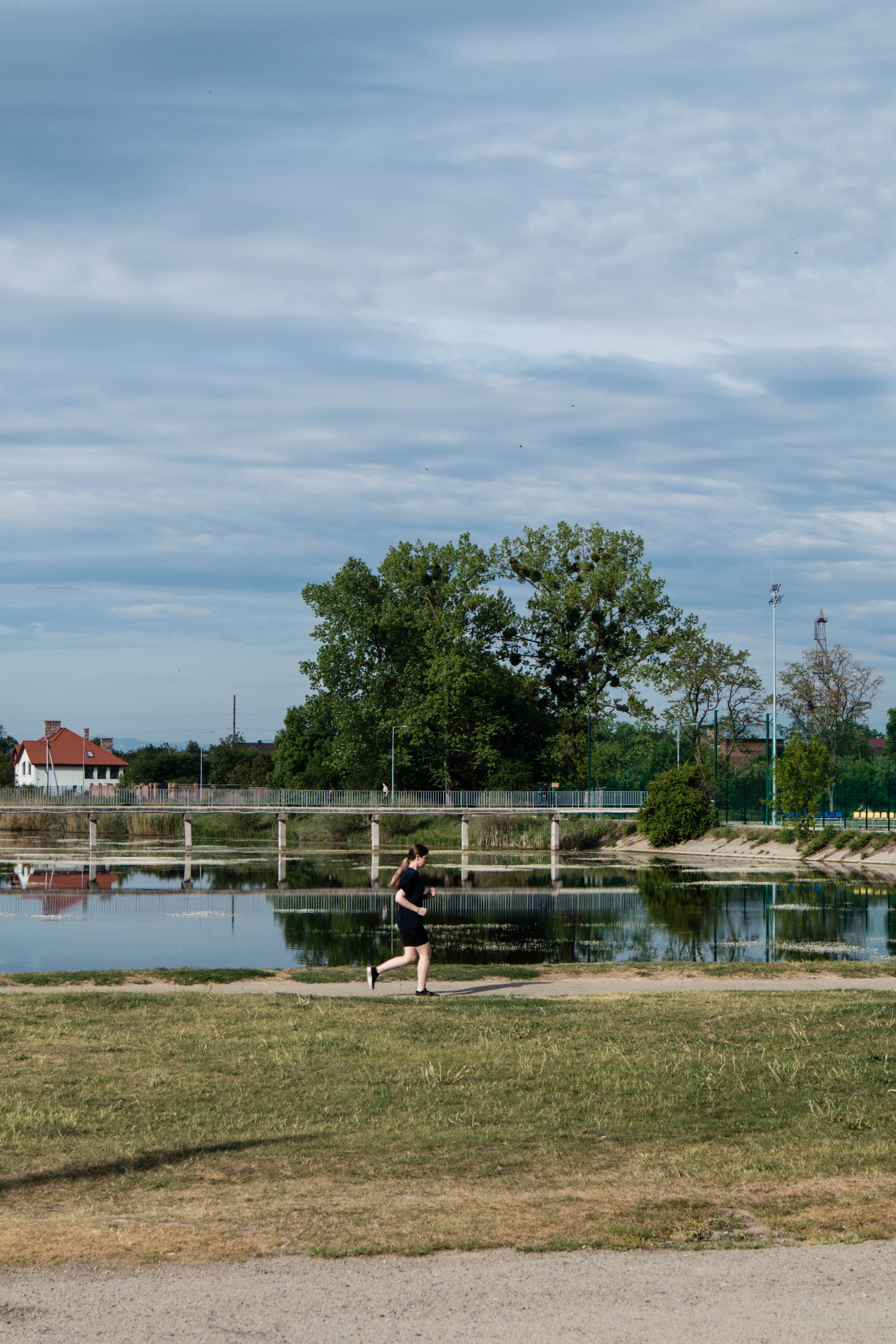 Photo of a Woman Jogging Near a Lake · Free Stock Photo