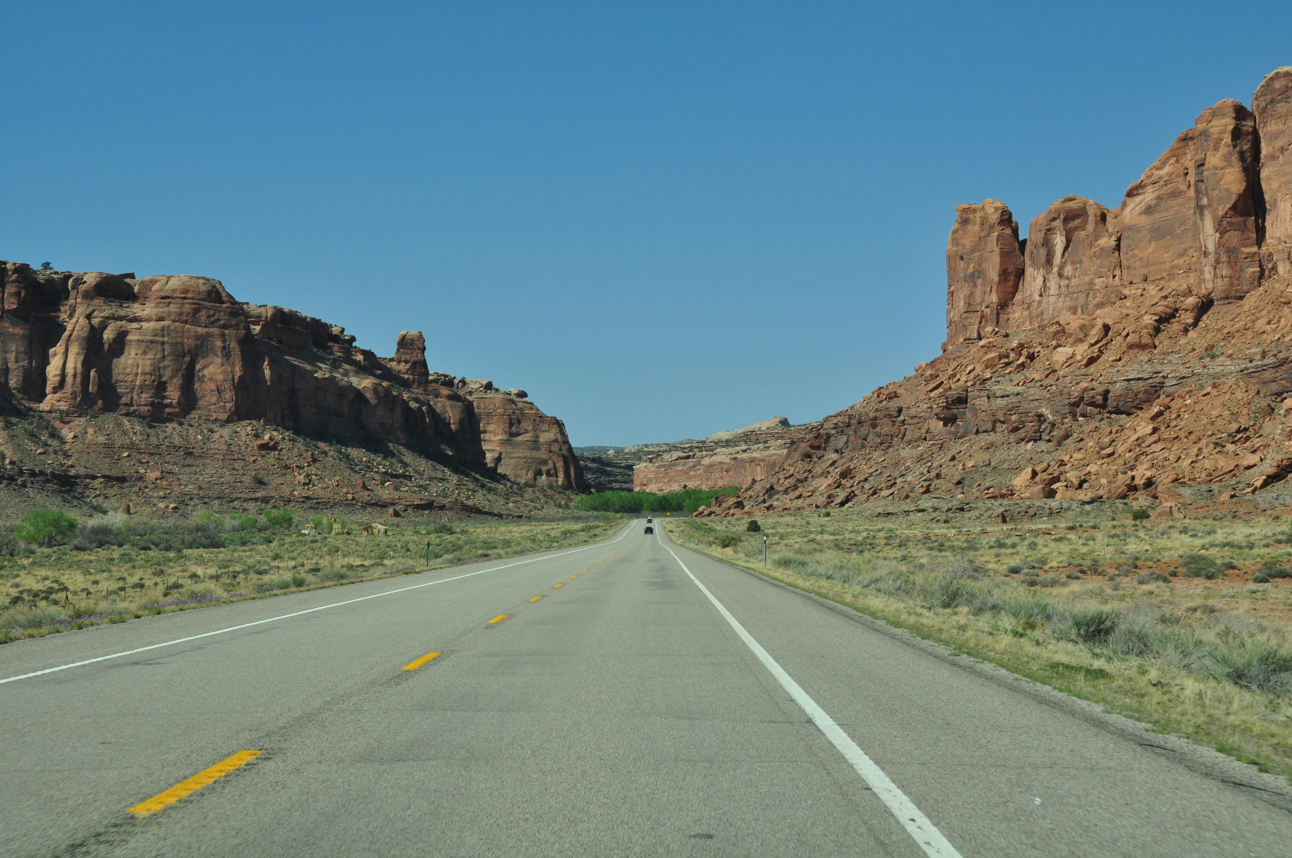 Asphalt Road Between Rock Formations Under Blue Sky · Free Stock Photo