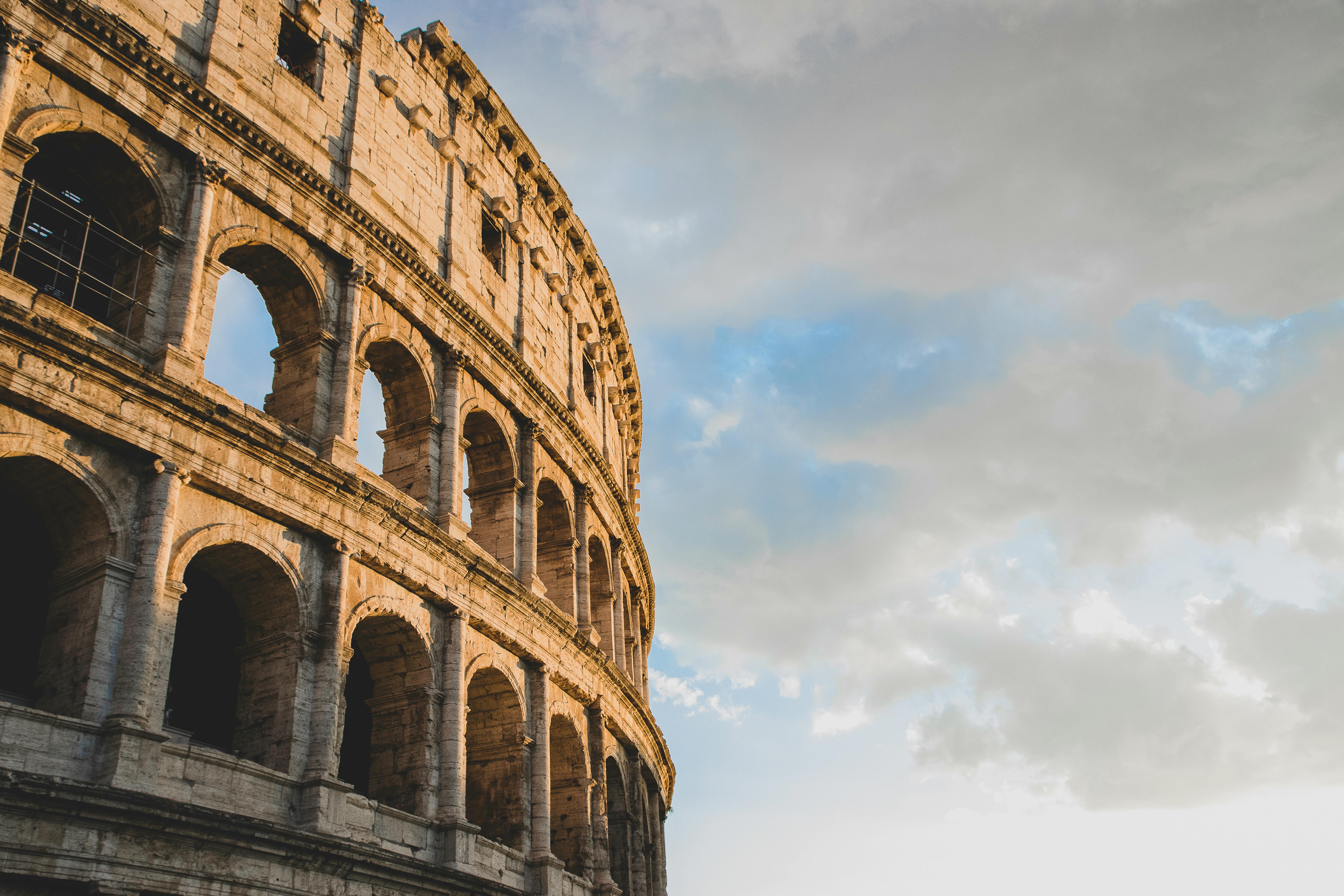 Coliseum with Arched Windows Under a Cloudy Blue Sky · Free Stock Photo