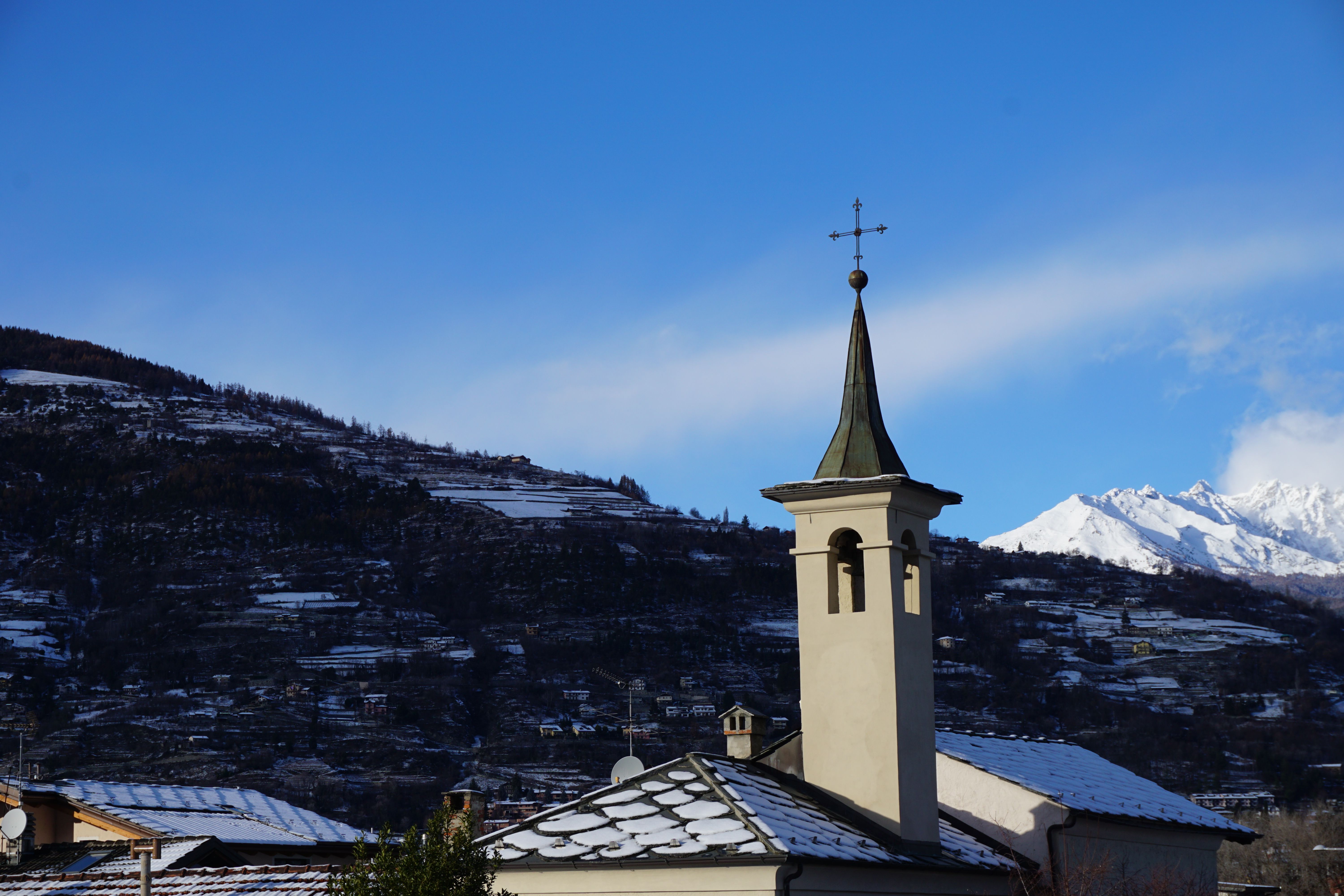 Landscape of a Church Tower in Front of a Landscape of the Mountains ...