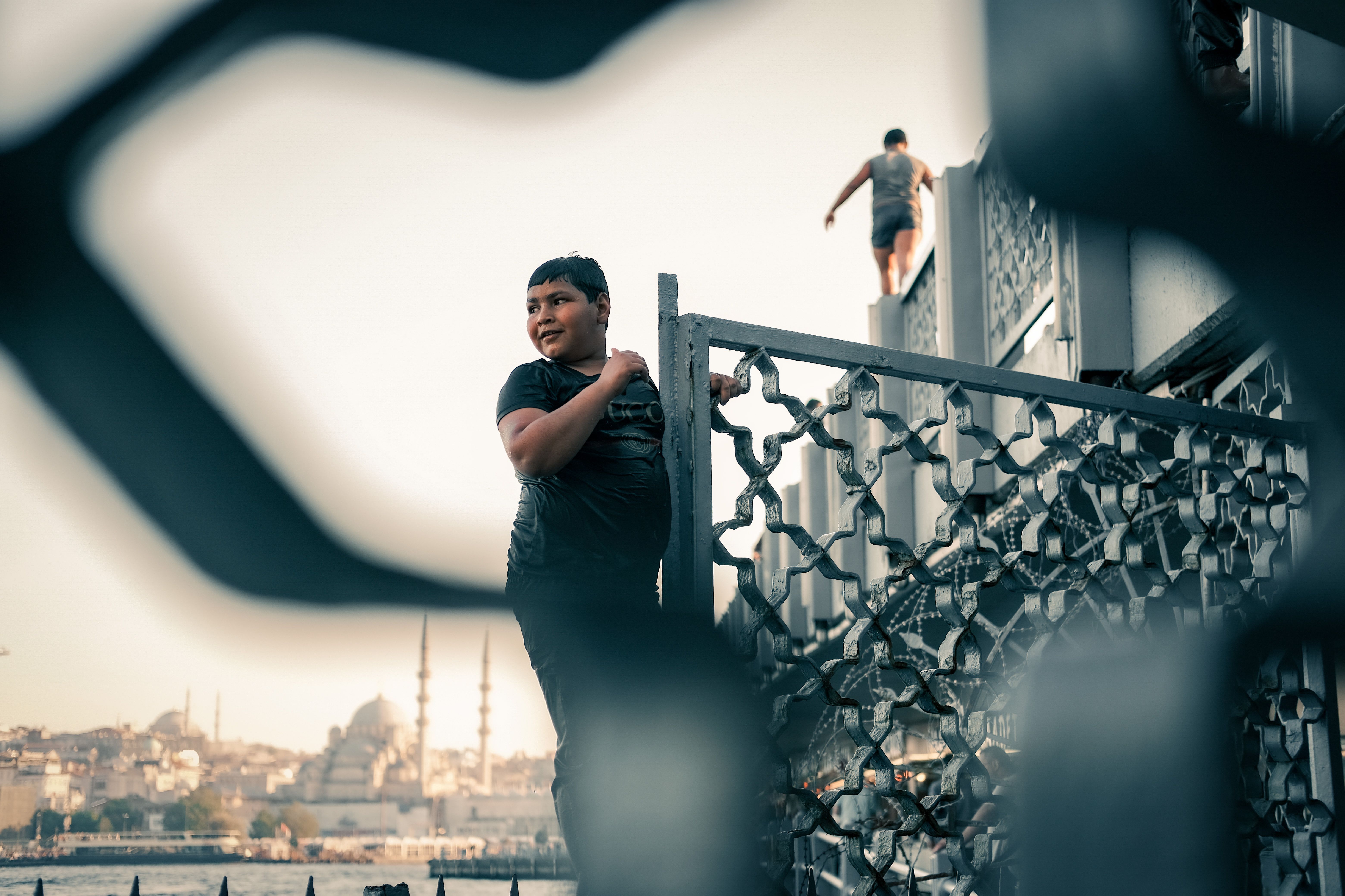 Young Boys Standing on Bridge Metal Fence · Free Stock Photo