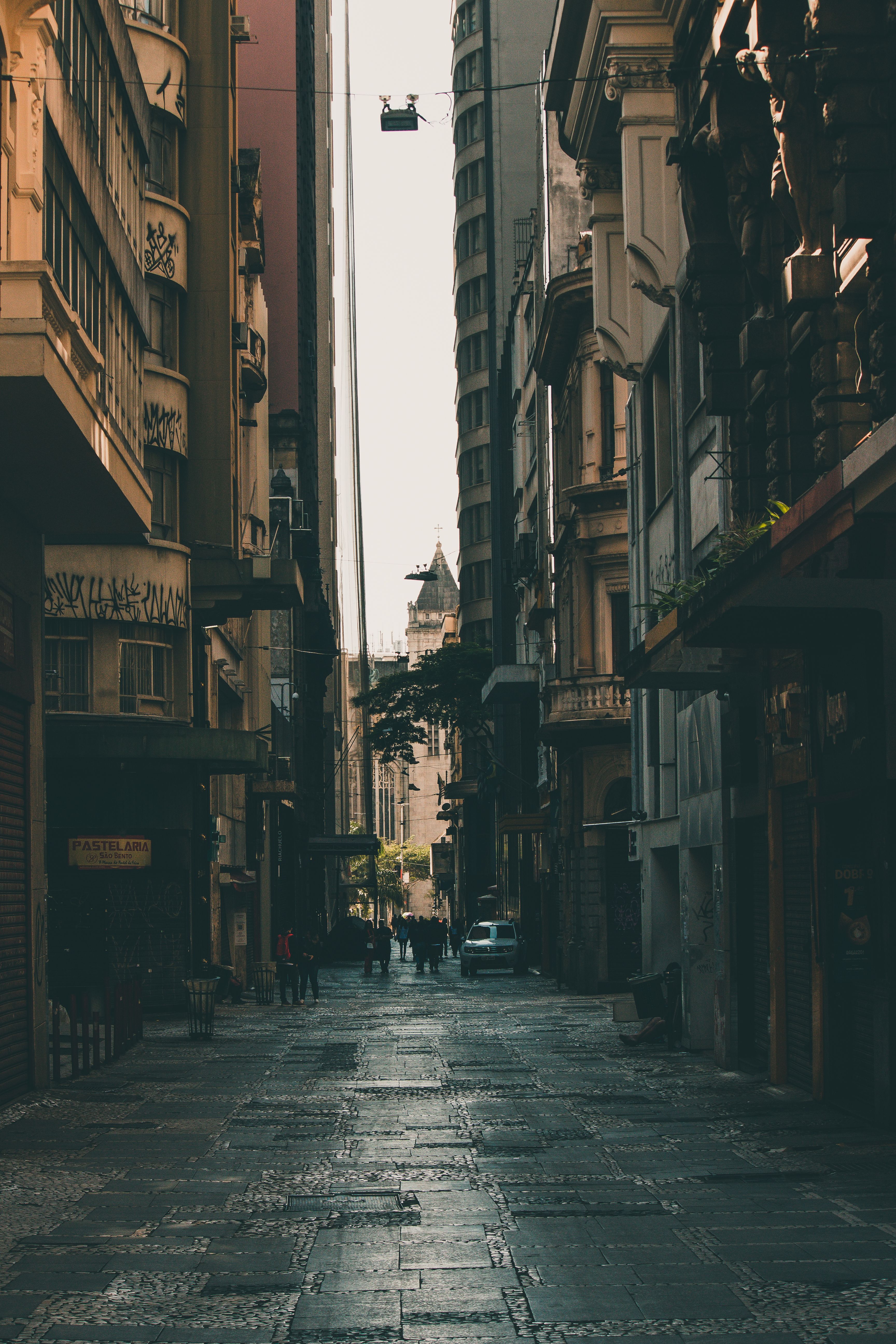 People Walking on Street Between Buildings · Free Stock Photo