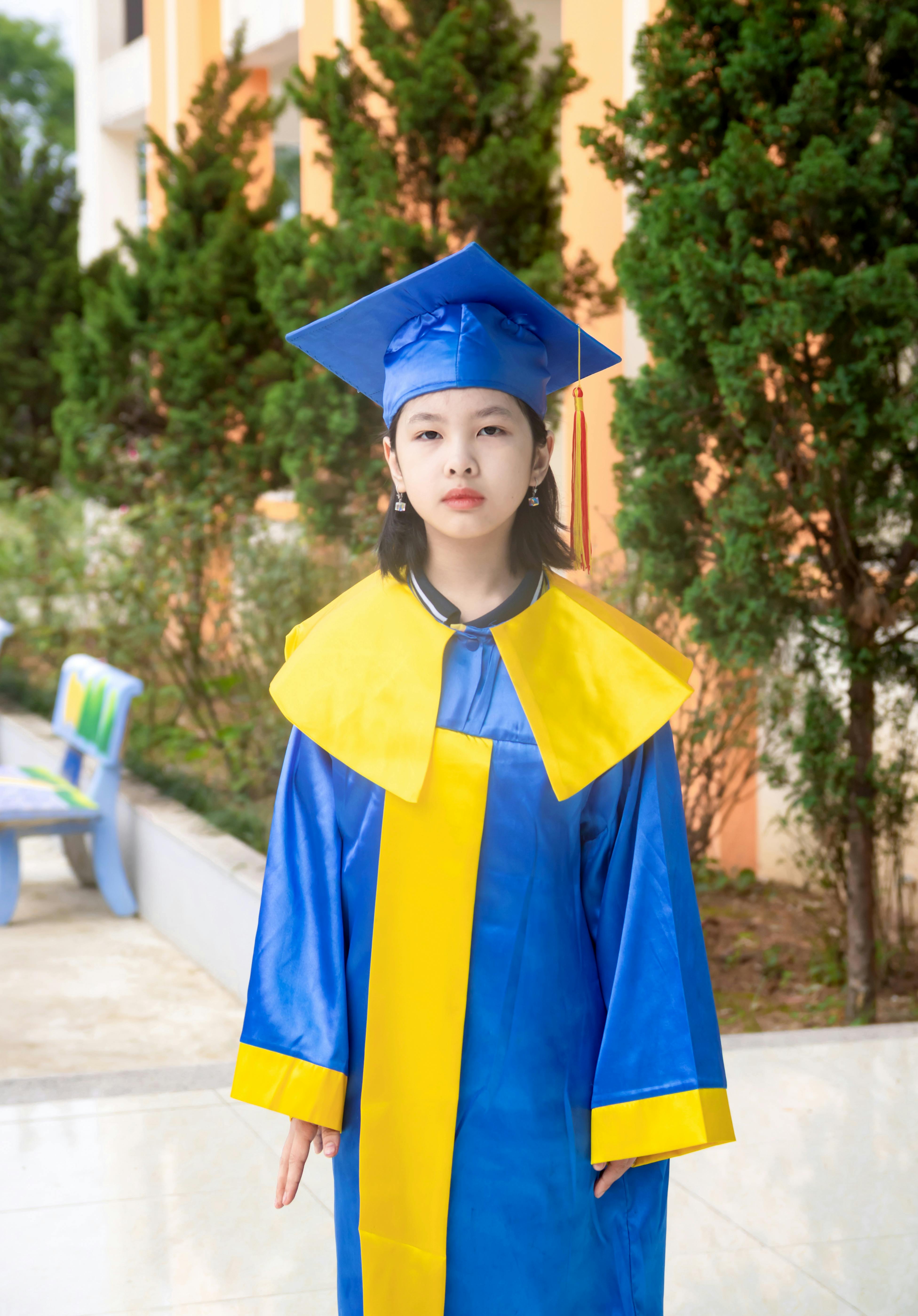 A Cute Little Girl Wearing Blue Toga while Looking at the Camera · Free ...