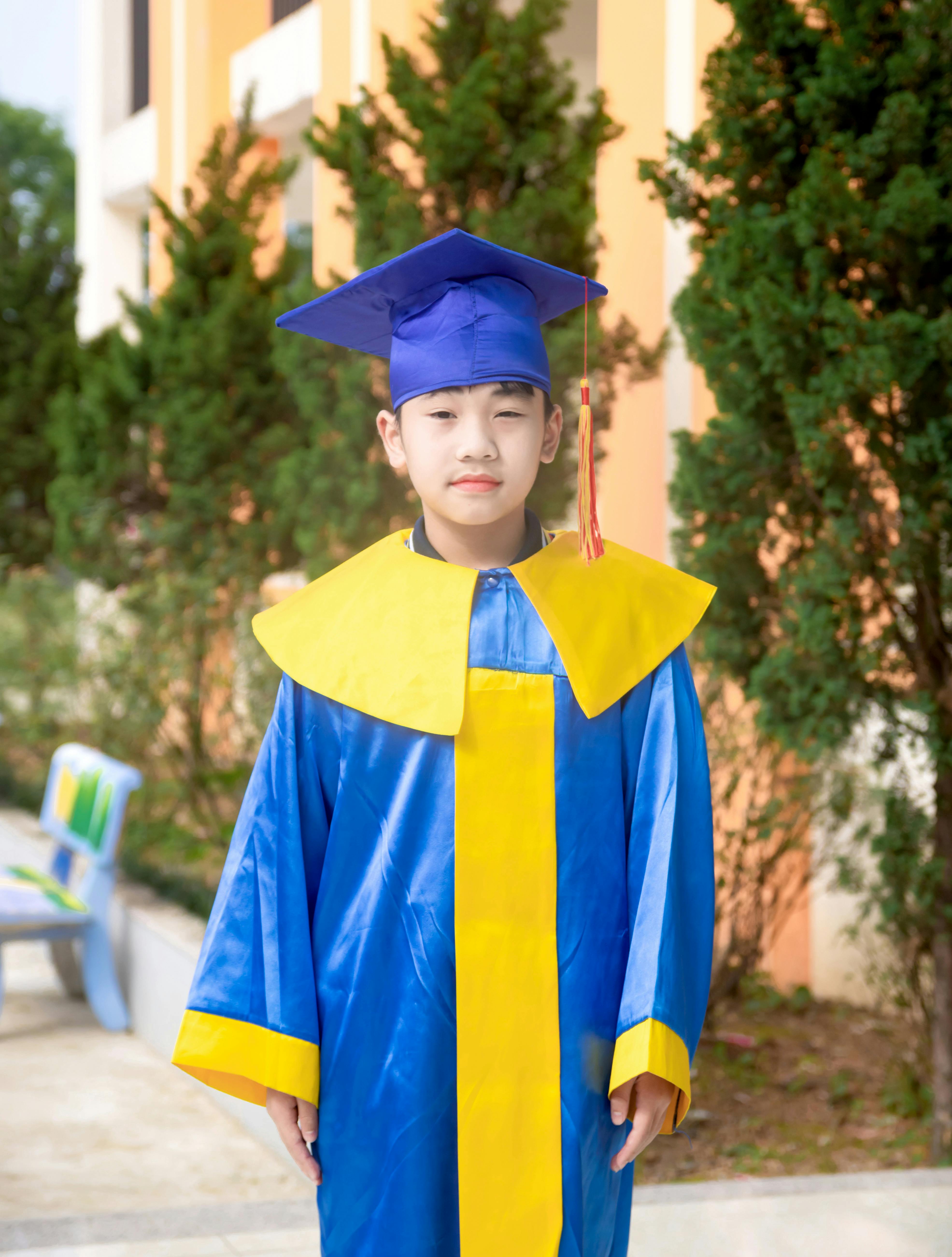 Young Boy Smiling in Graduation Gown and Cap · Free Stock Photo