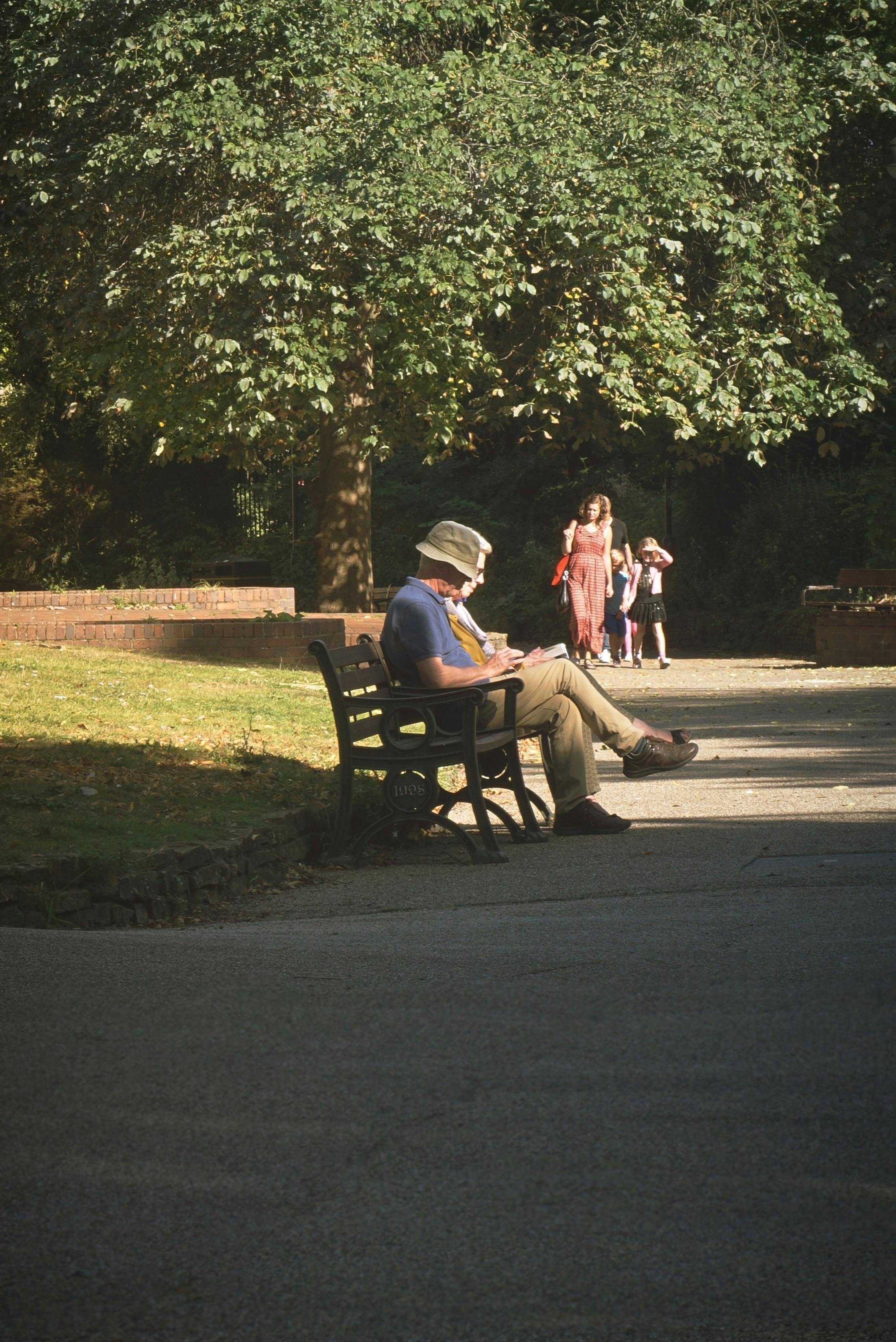 Two People Sitting On A Park Bench · Free Stock Photo
