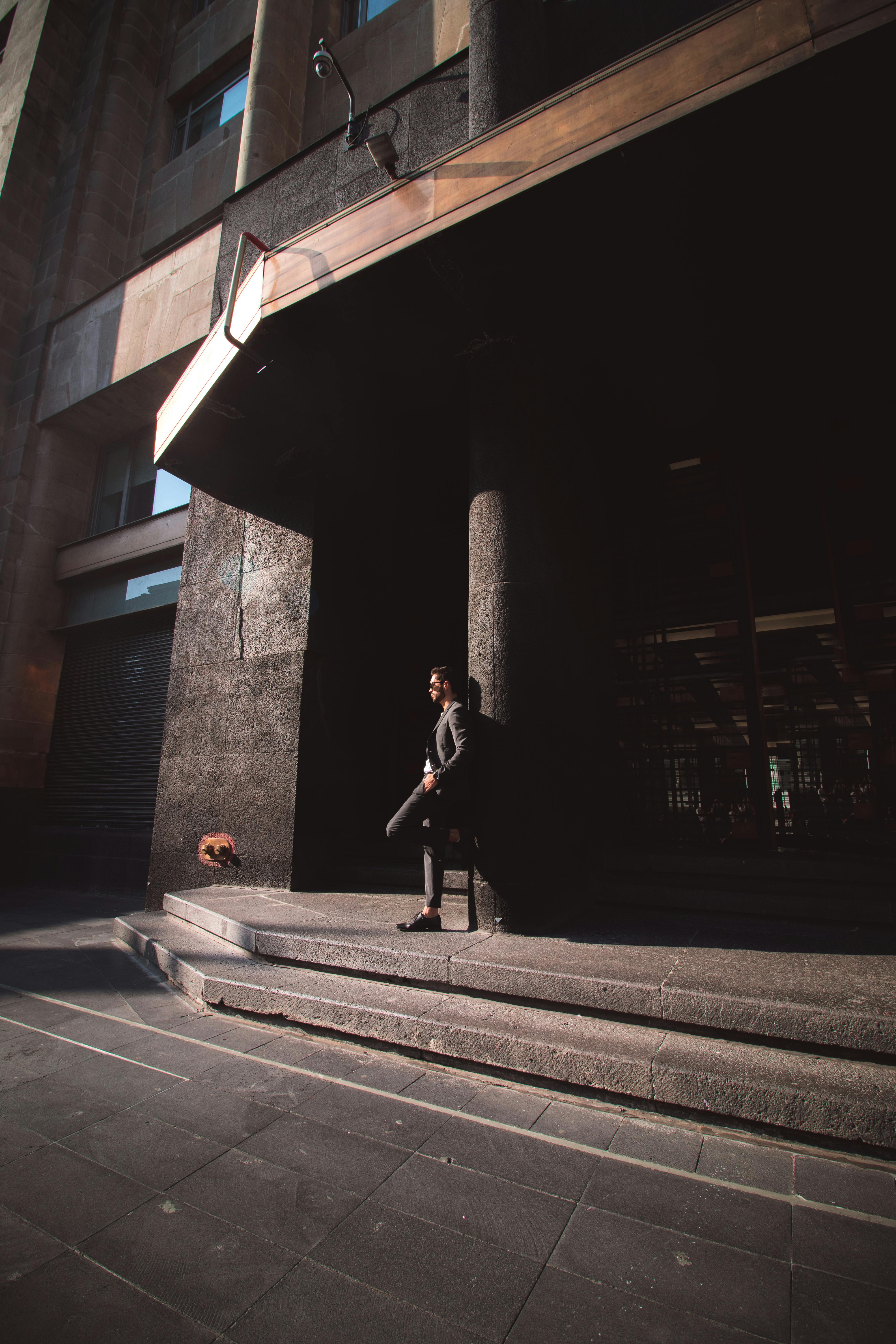 Man Leaning Against Concrete Wall · Free Stock Photo