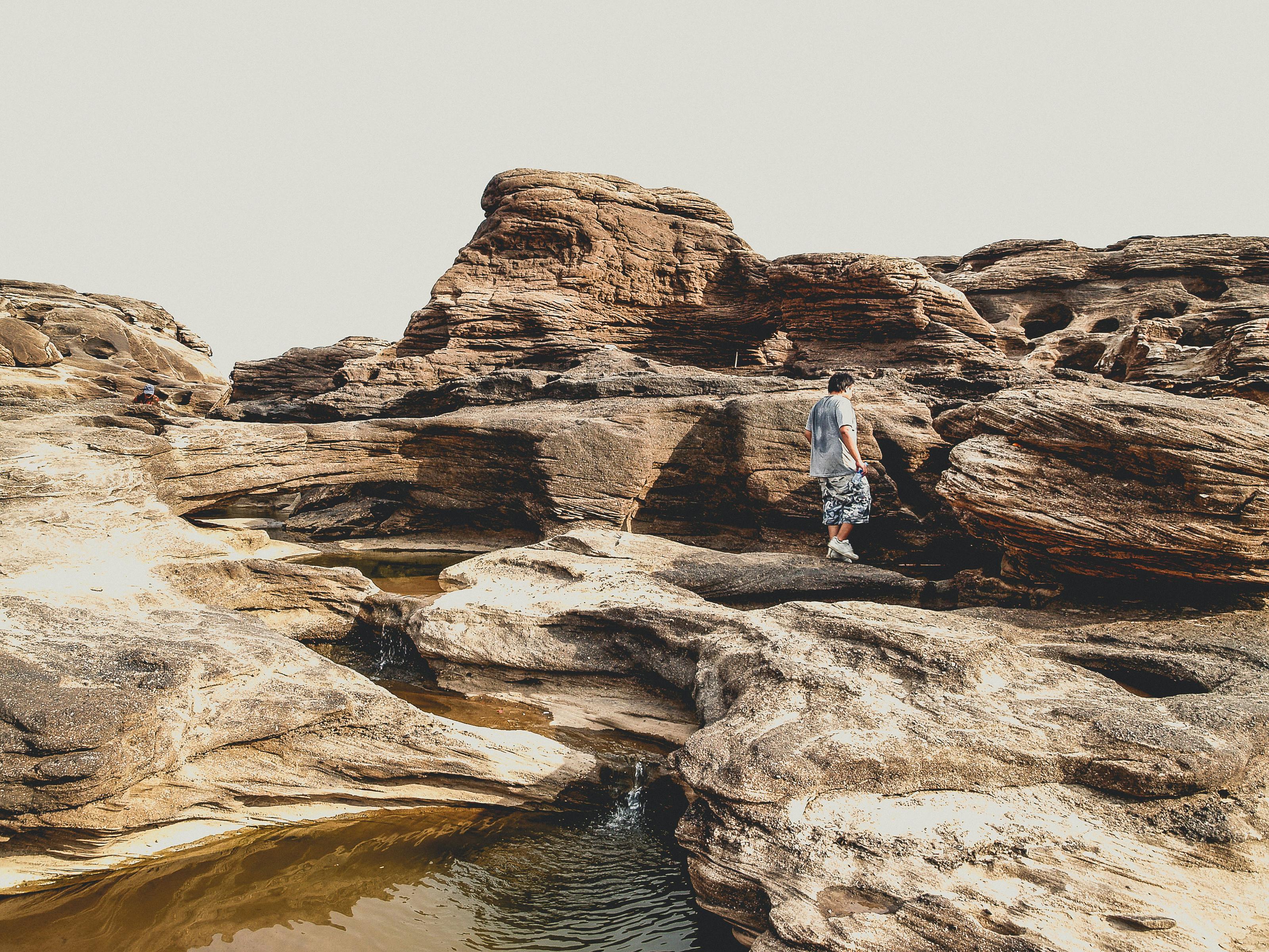 Close-up Photo of Brown rocks Beside Body of Water · Free Stock Photo